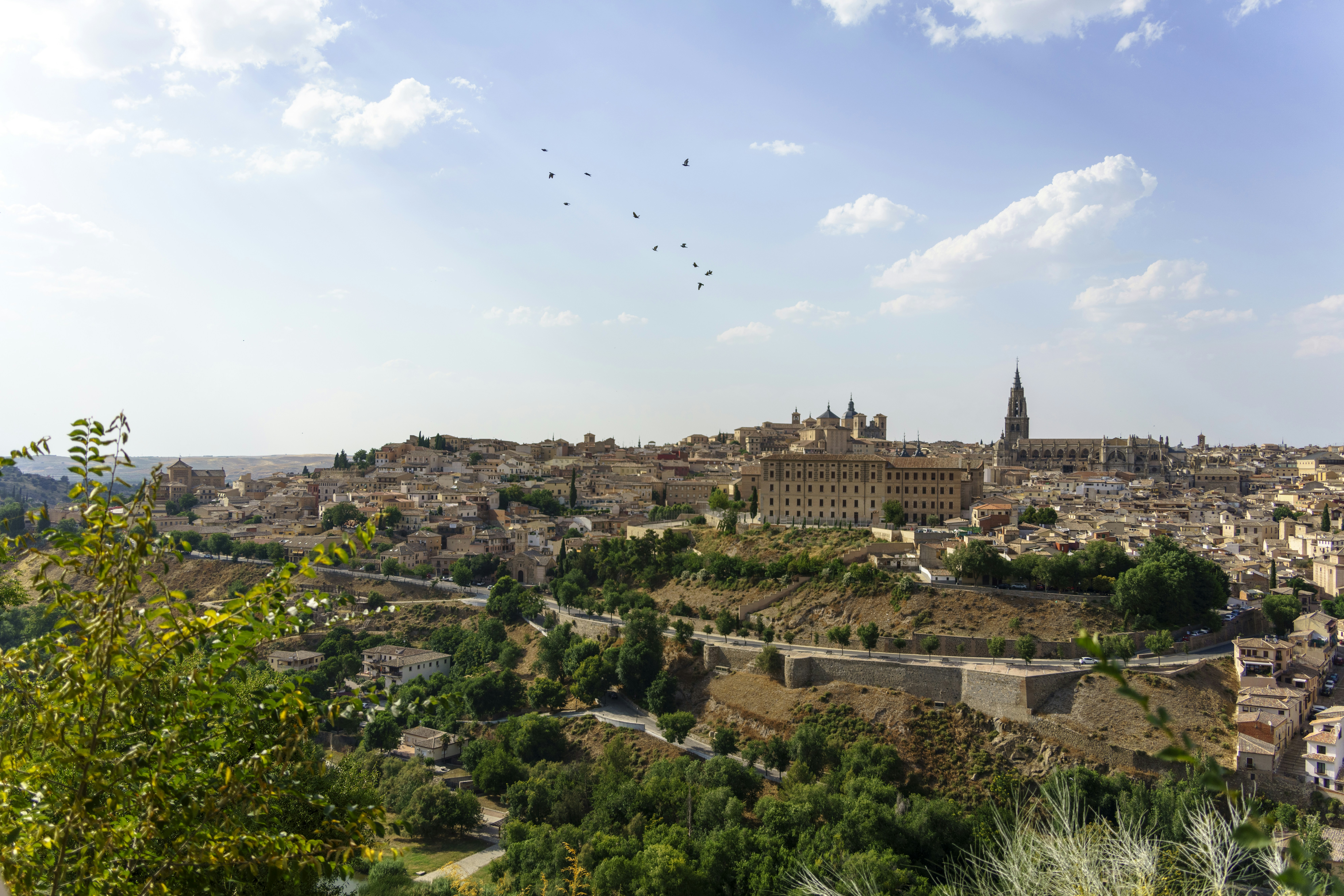 Expansive view of Toledo's historic skyline under a partly cloudy sky.