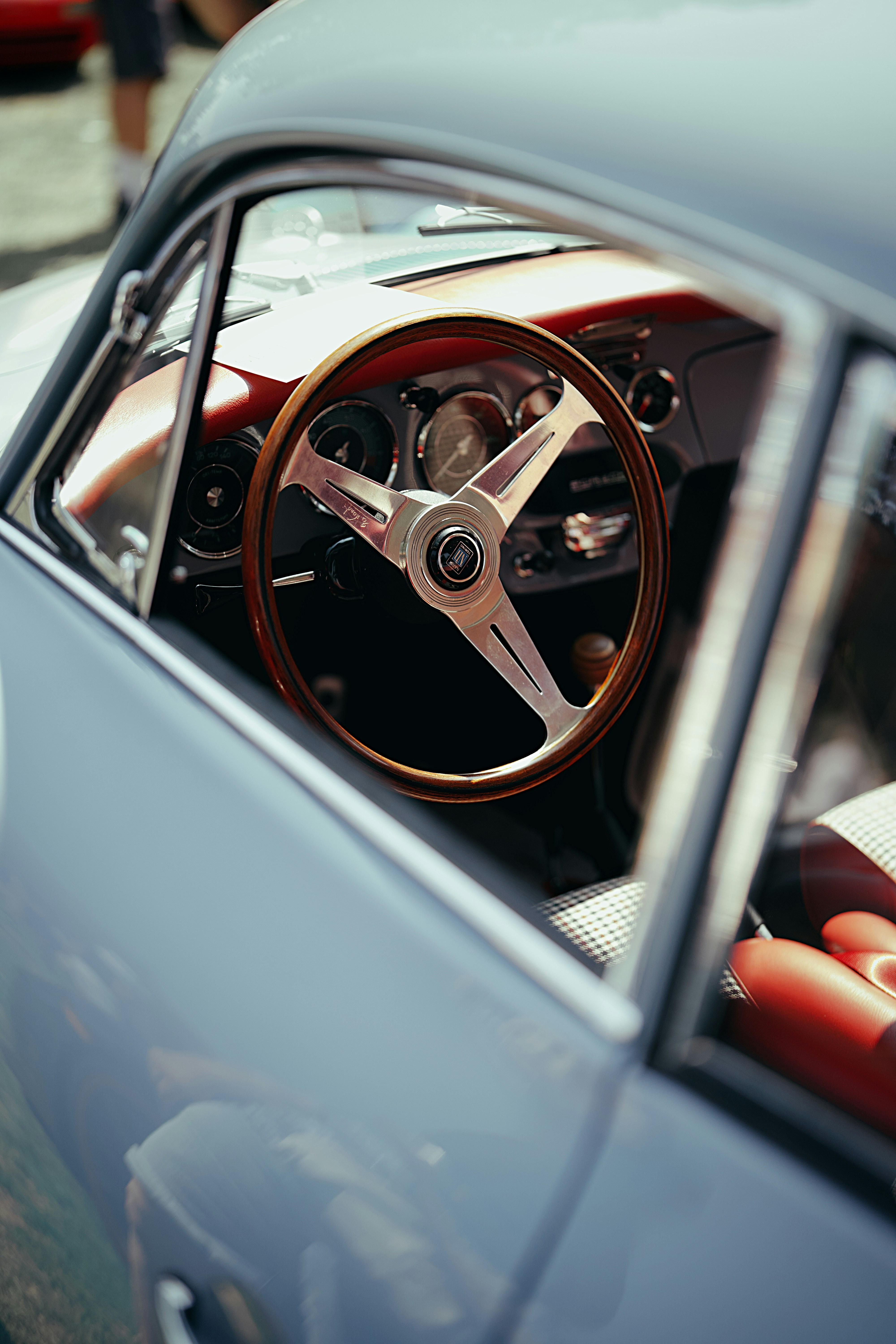 Steering wheel of an old Porsche | A close up of a car with a steering wheel