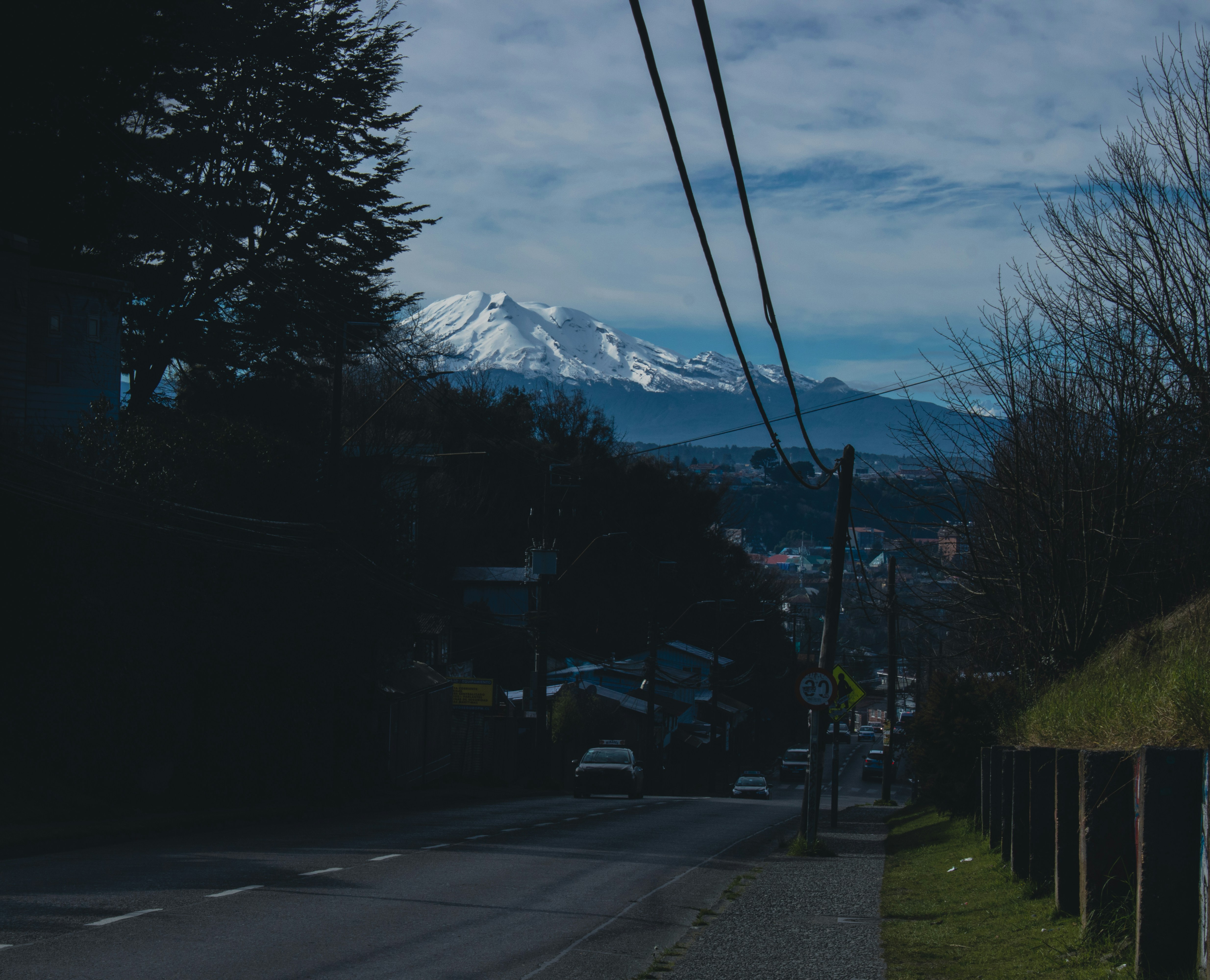 Snow-Capped Crest Framed by Power Lines Along a Quiet Suburban Road