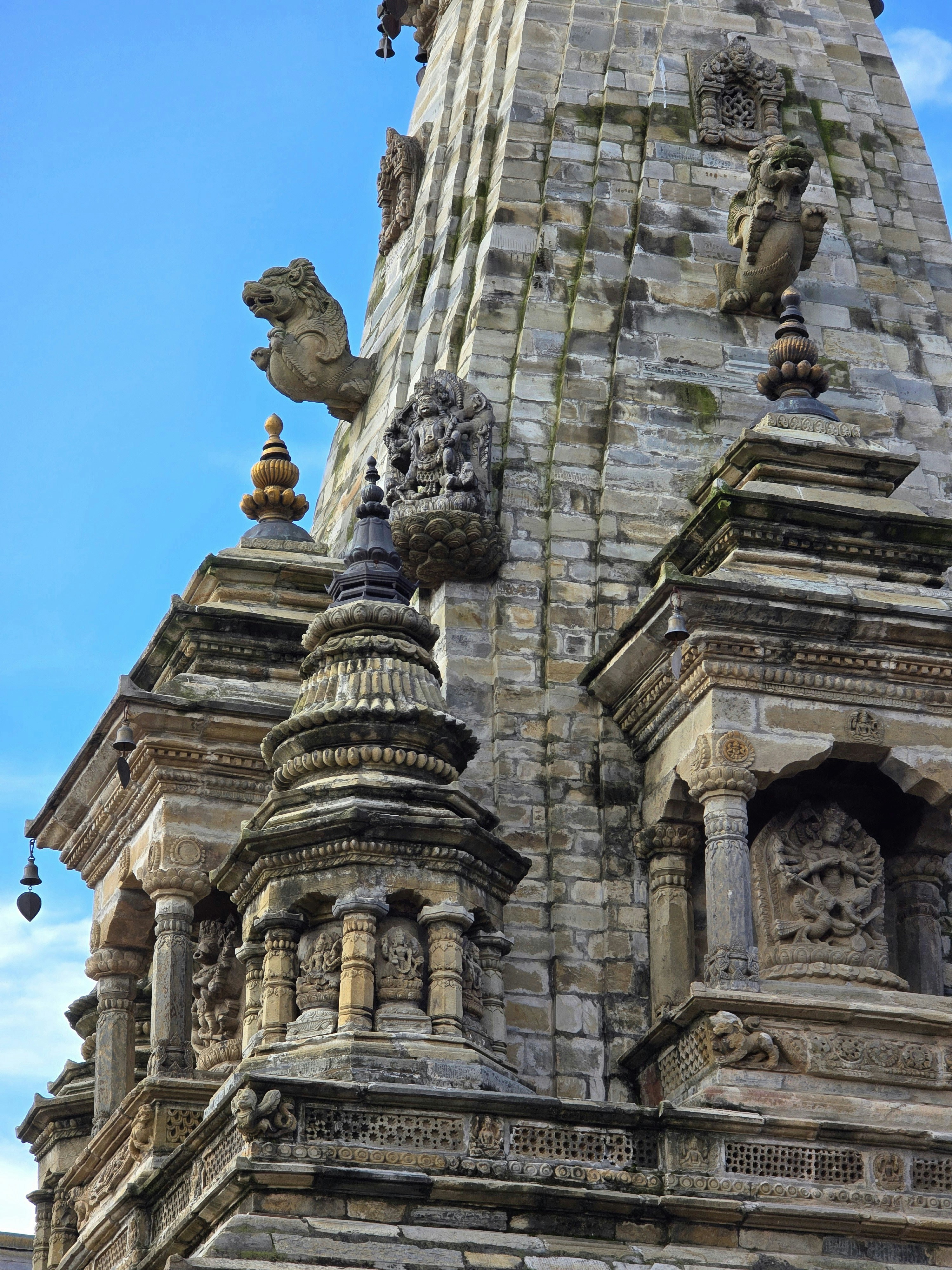 Tiered Stone Spires and Guardian Carvings on a Weathered Temple Facade