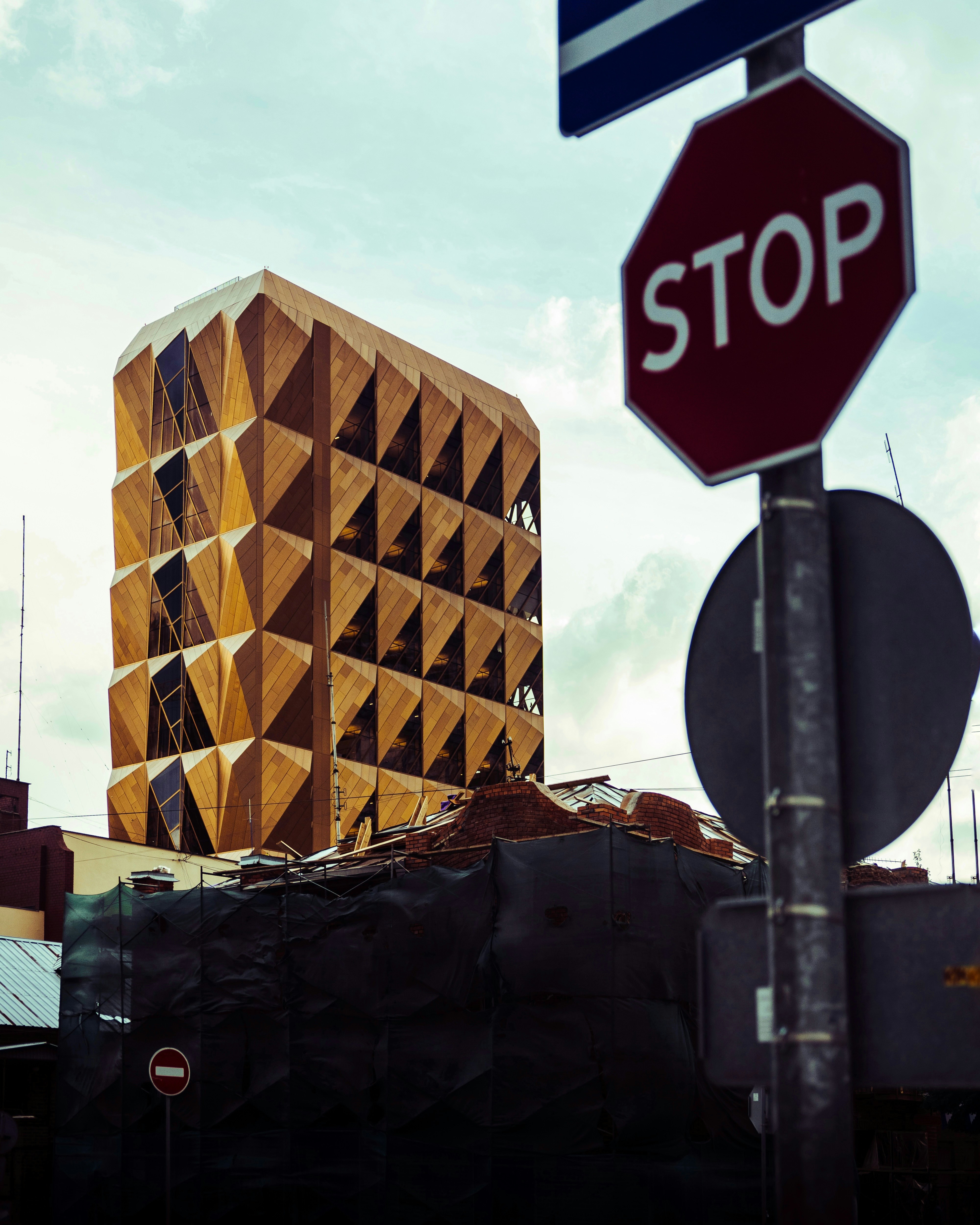 Diamond Facade Rising: Timber Geometry Over a Street Under Construction