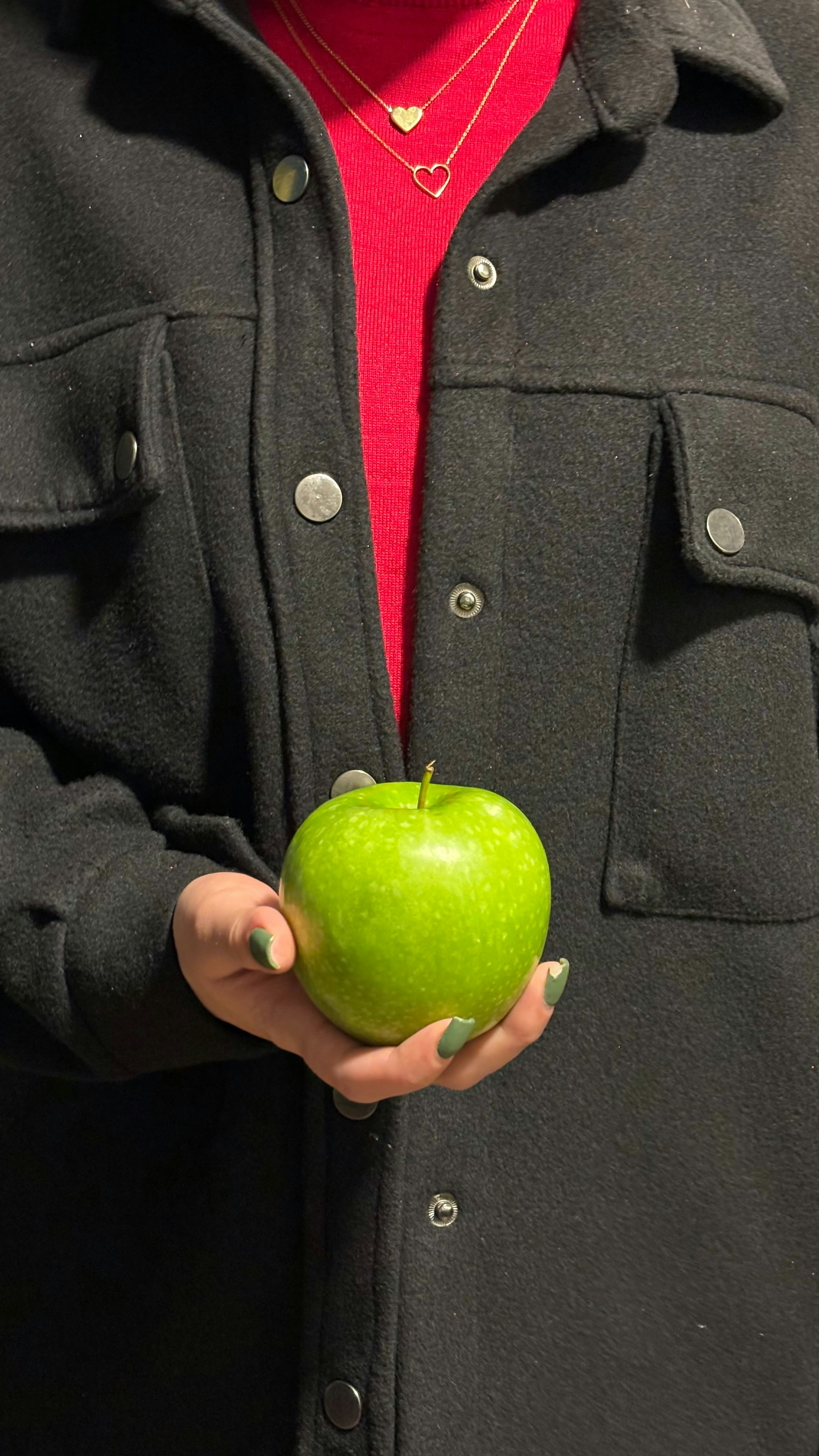 Emerald Apple in a Dark Wardrobe: A Quiet Close-Up