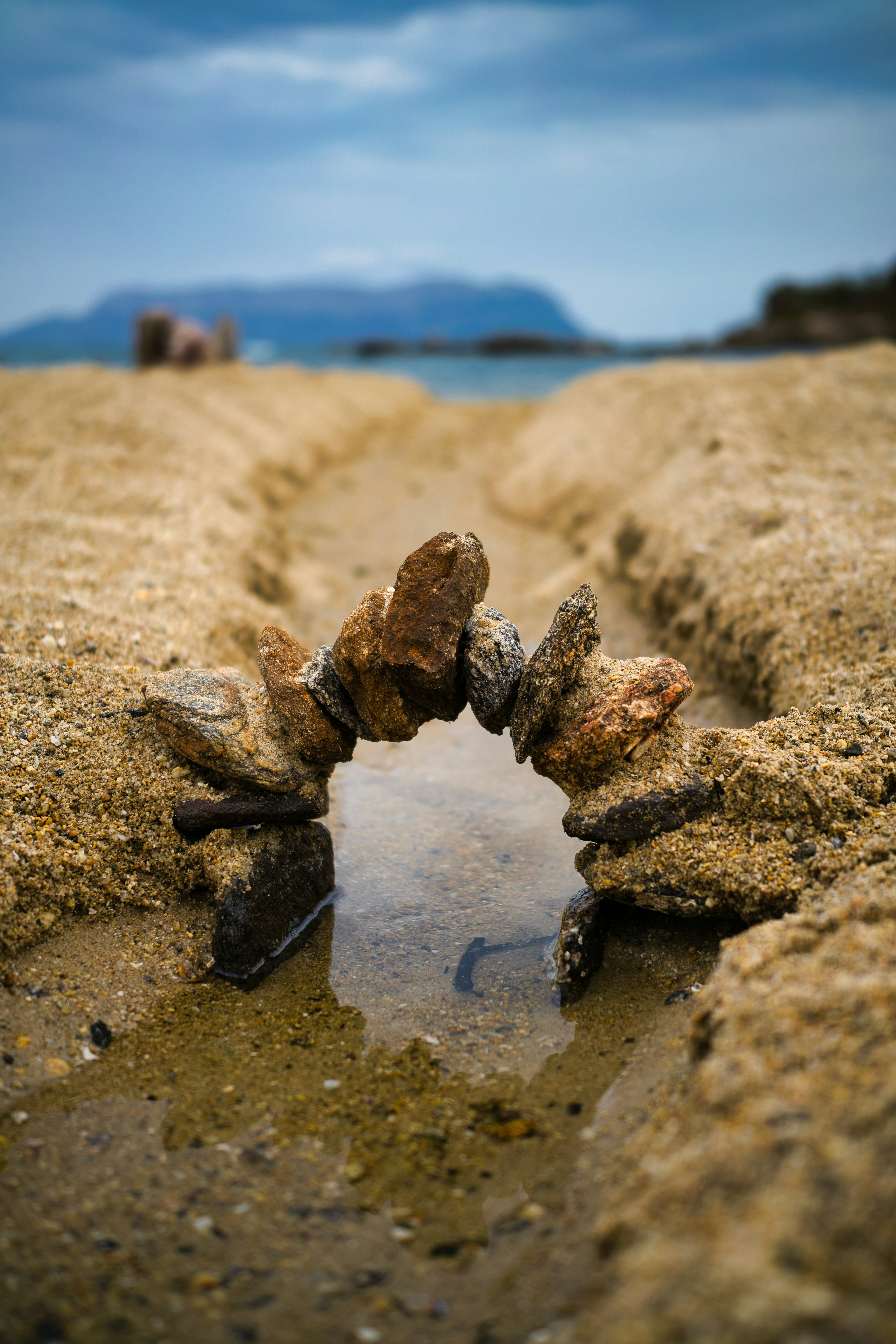 A puddle of water in the middle of a sandy beach photo – Free Beach ...