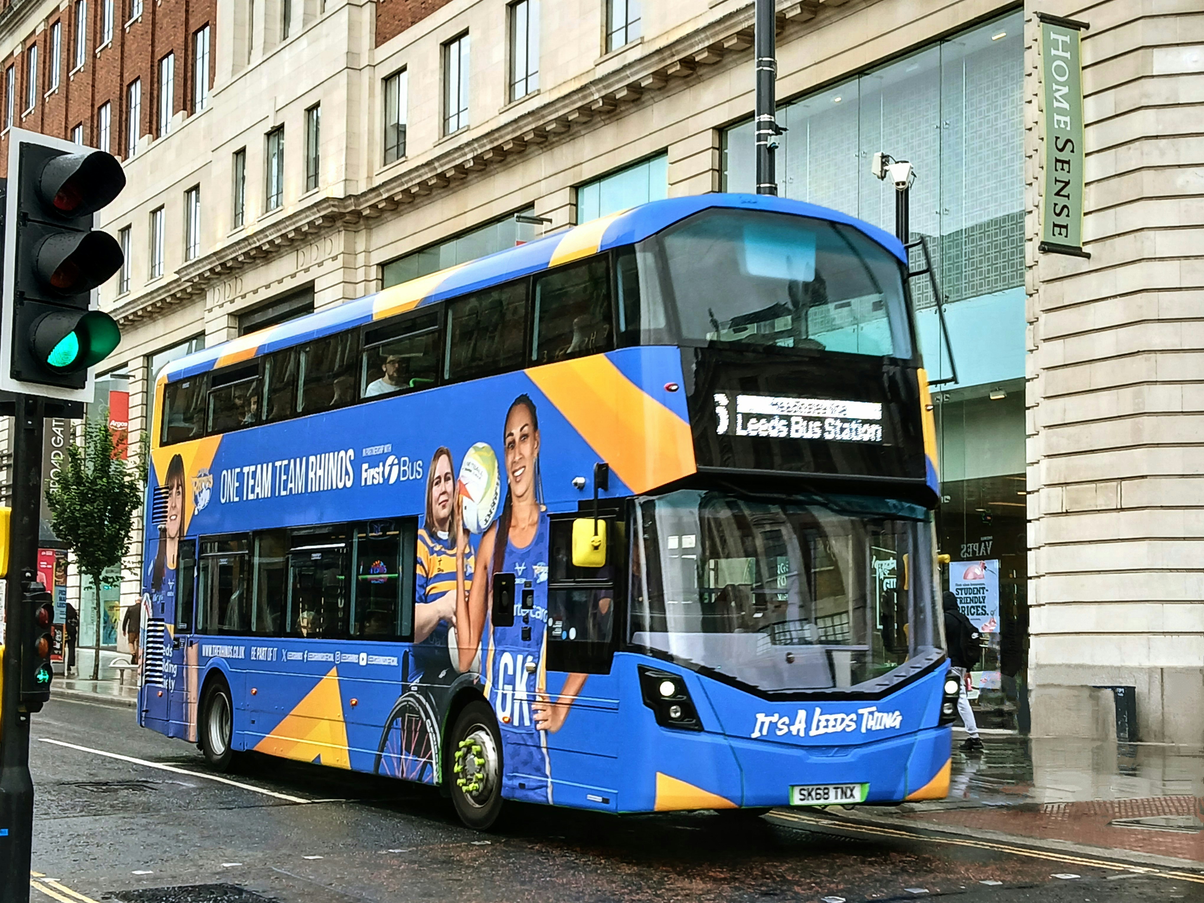 A blue double decker bus driving down a street photo – Free Bus Image ...