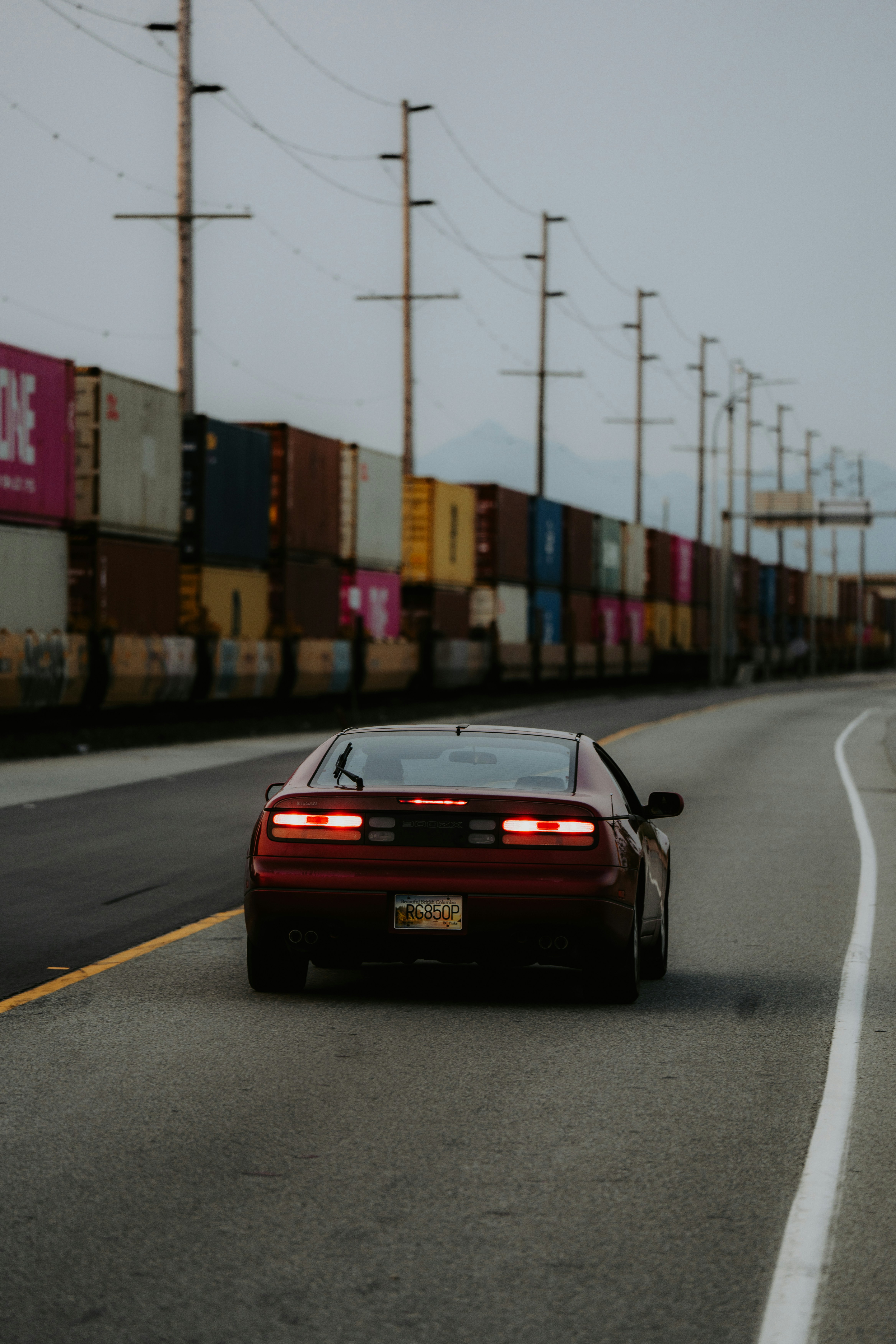 A car driving down a road next to a train photo – Free Road Image on ...