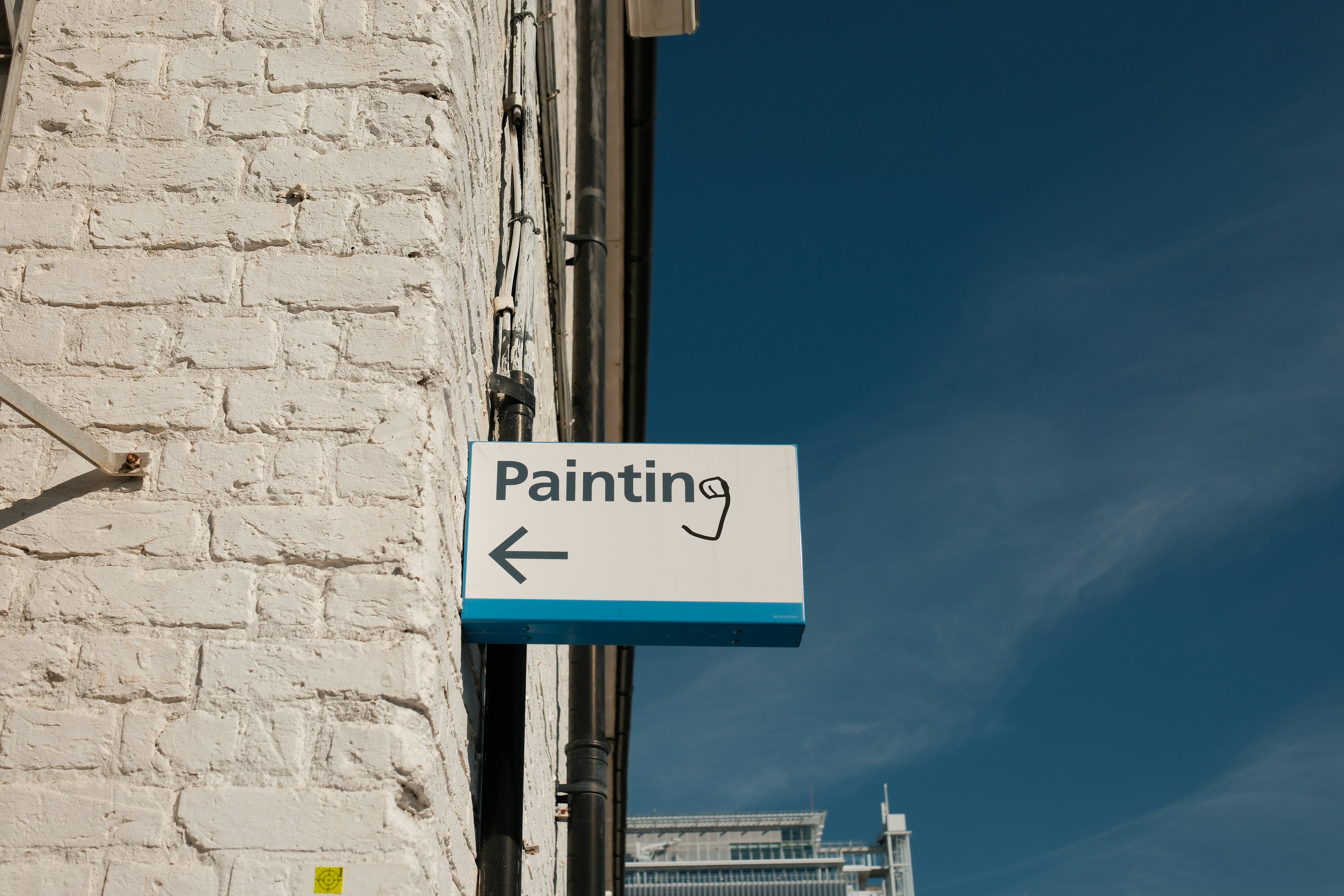A white brick building with a sign that says painting photo – Free ...