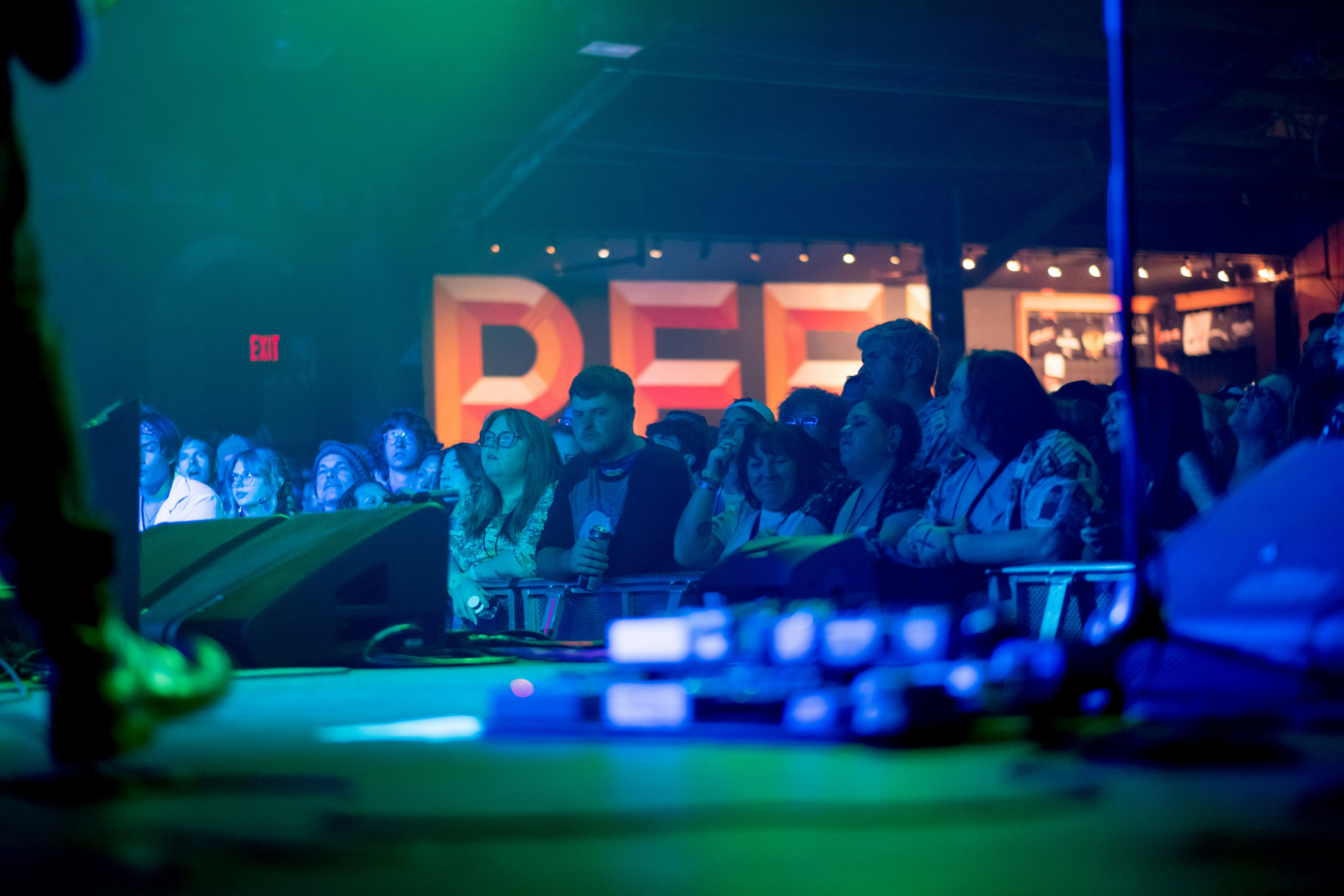 Neon-lit Crowd at a Club with a Backlit Sign