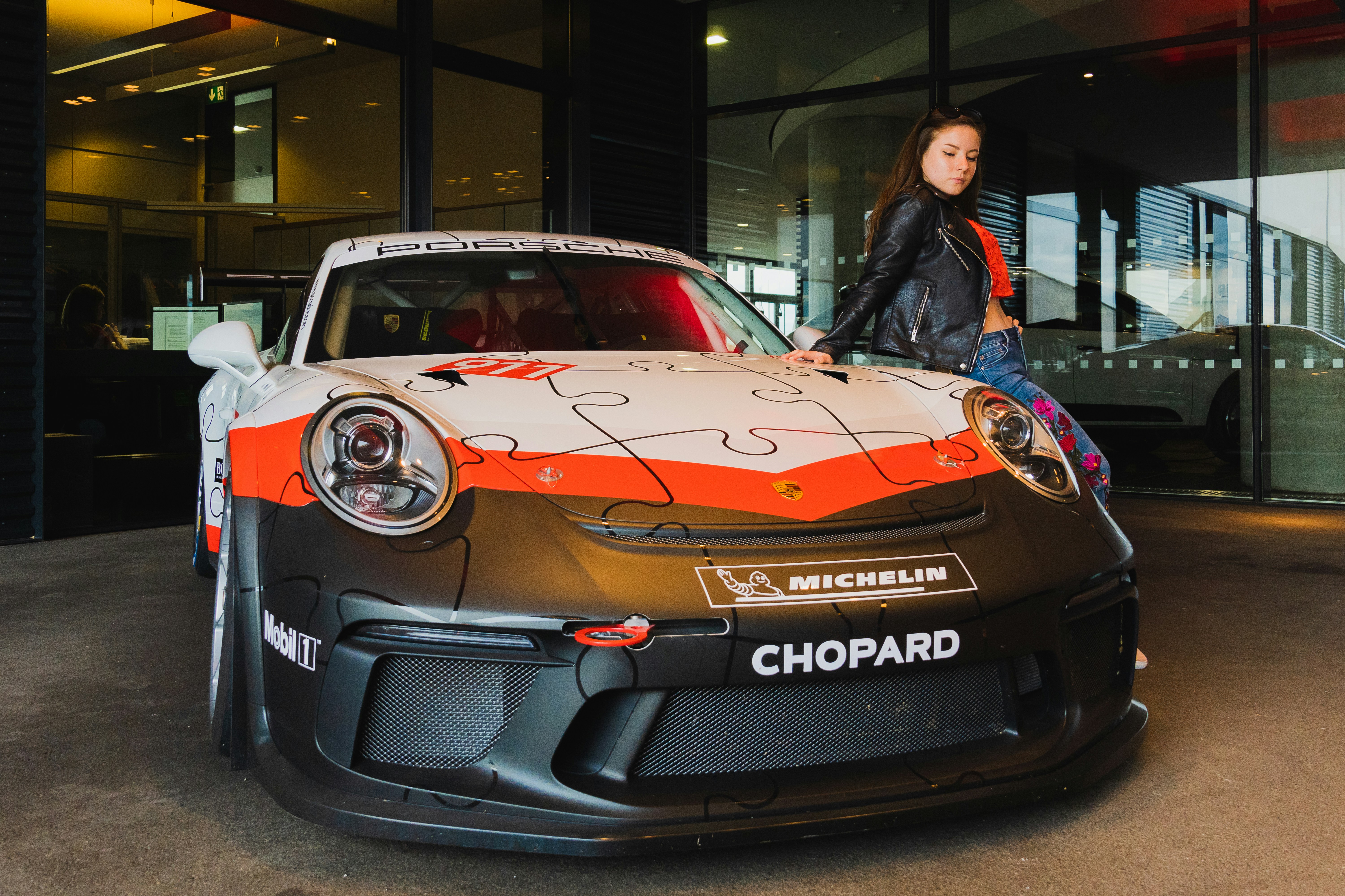 Showroom Sprint: Porsche 911 GT3's Race-Ready Glow Beside a Poised Model