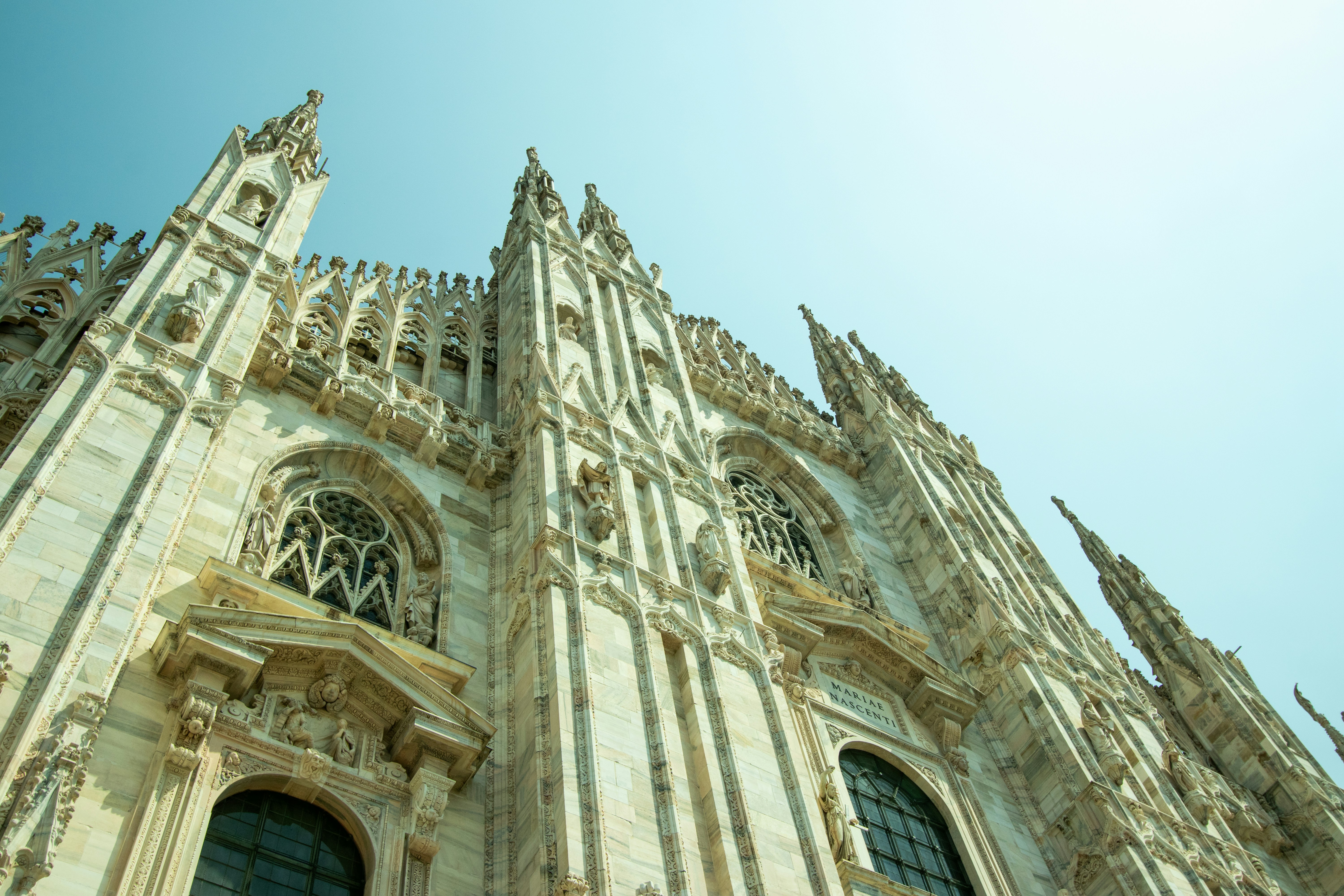 Pale Limestone Spires Toward a Clear Sky: Close-Up of a Gothic Cathedral Façade