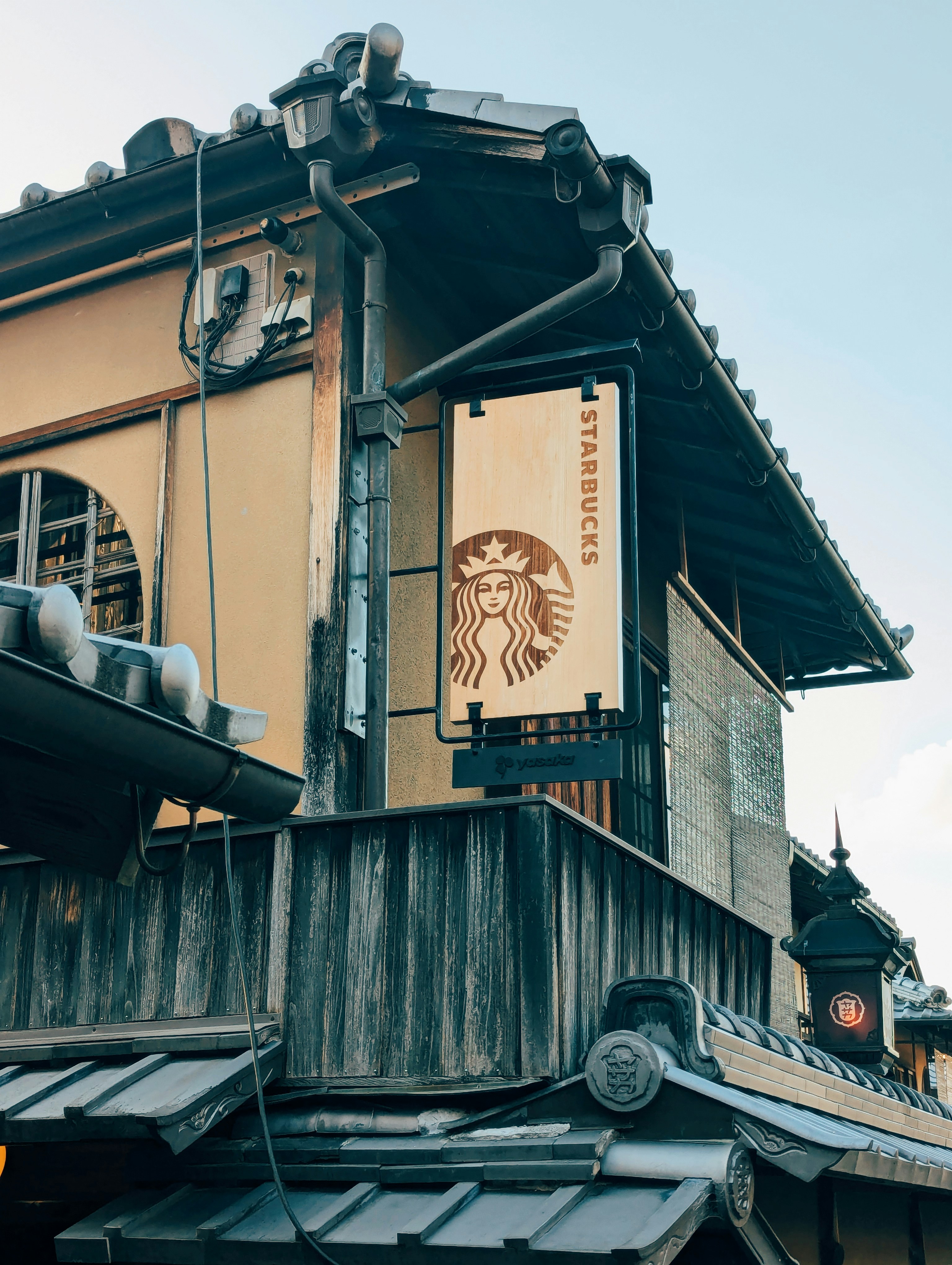Starbucks Sign Adorning a Weathered Timber Facade Under a Tiled Roof