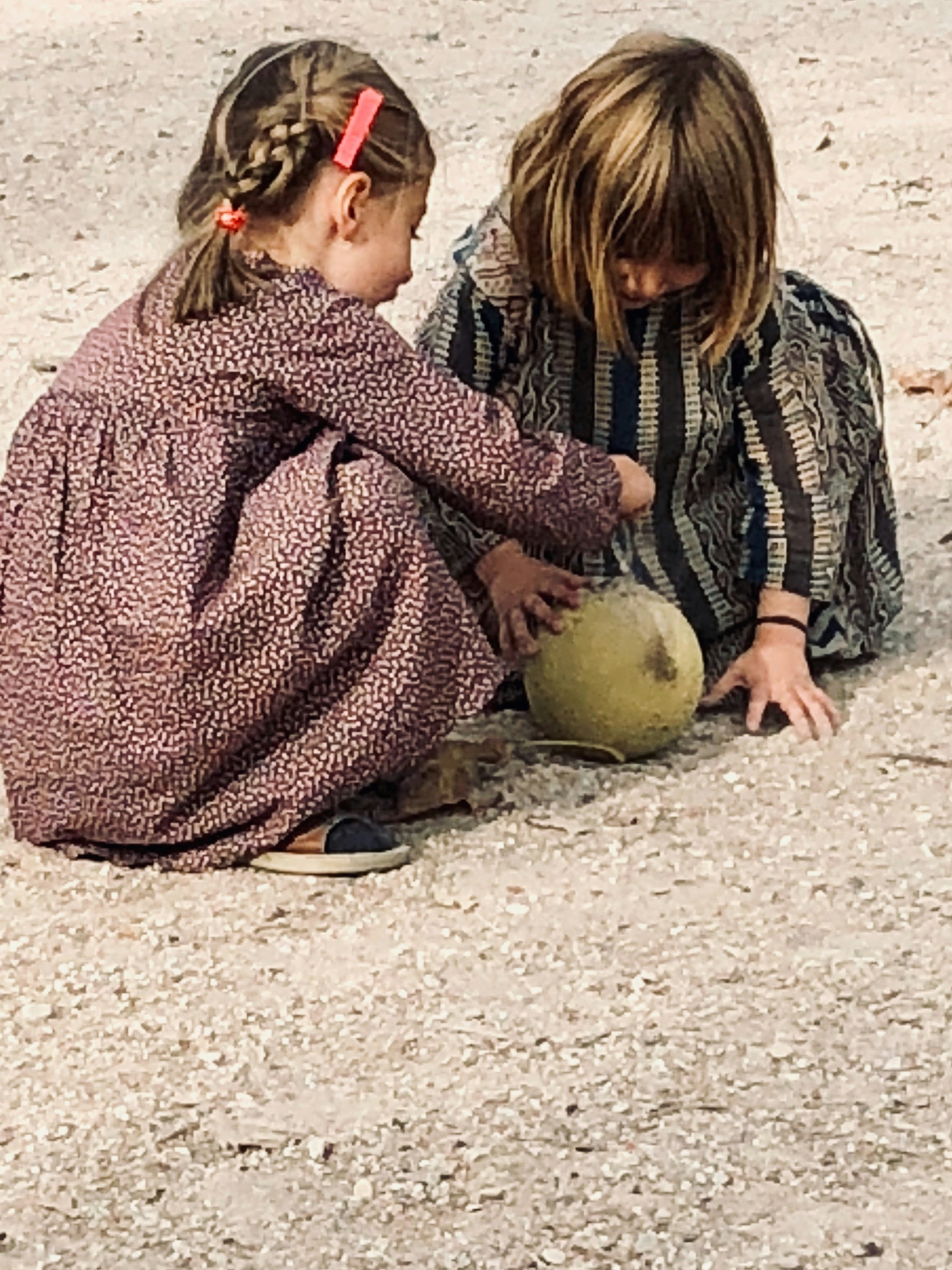 Gravel Moment: Two Girls Uncover a Melon With Quiet Curiosity