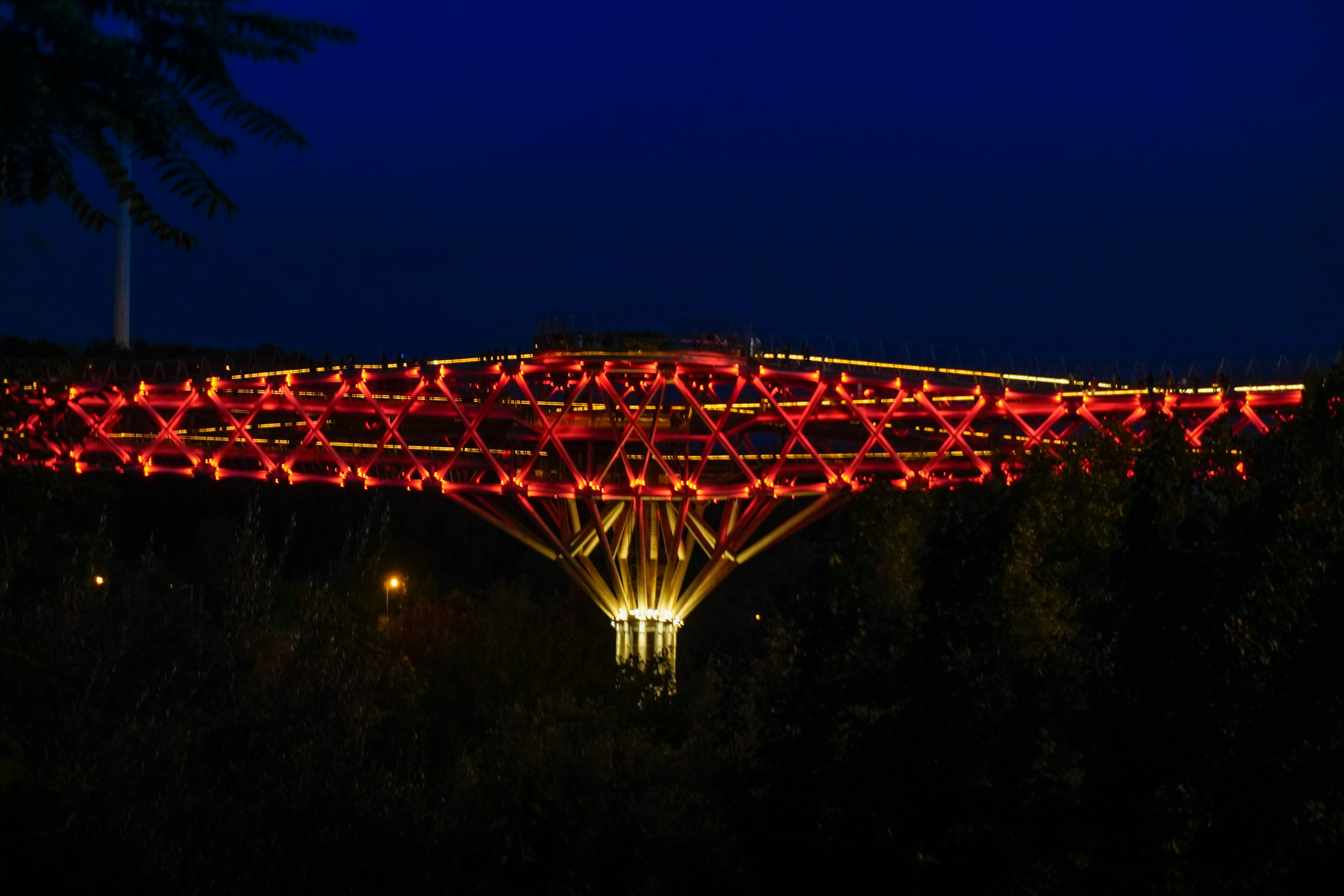 A red bridge lit up at night with lights on it photo – Free City Image ...