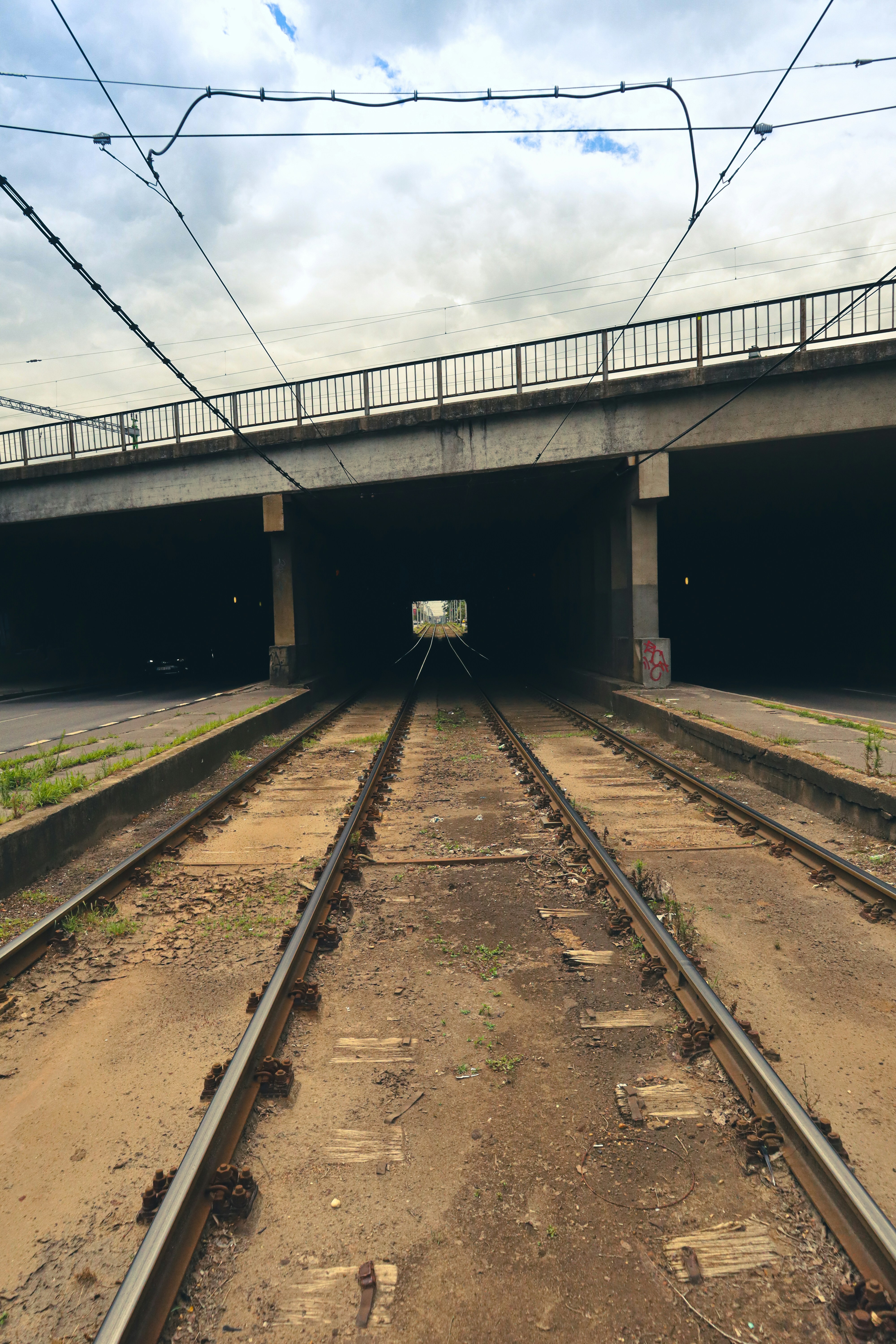 Convergence Under the Bridge: Rails Stretch Toward a Distant Exit