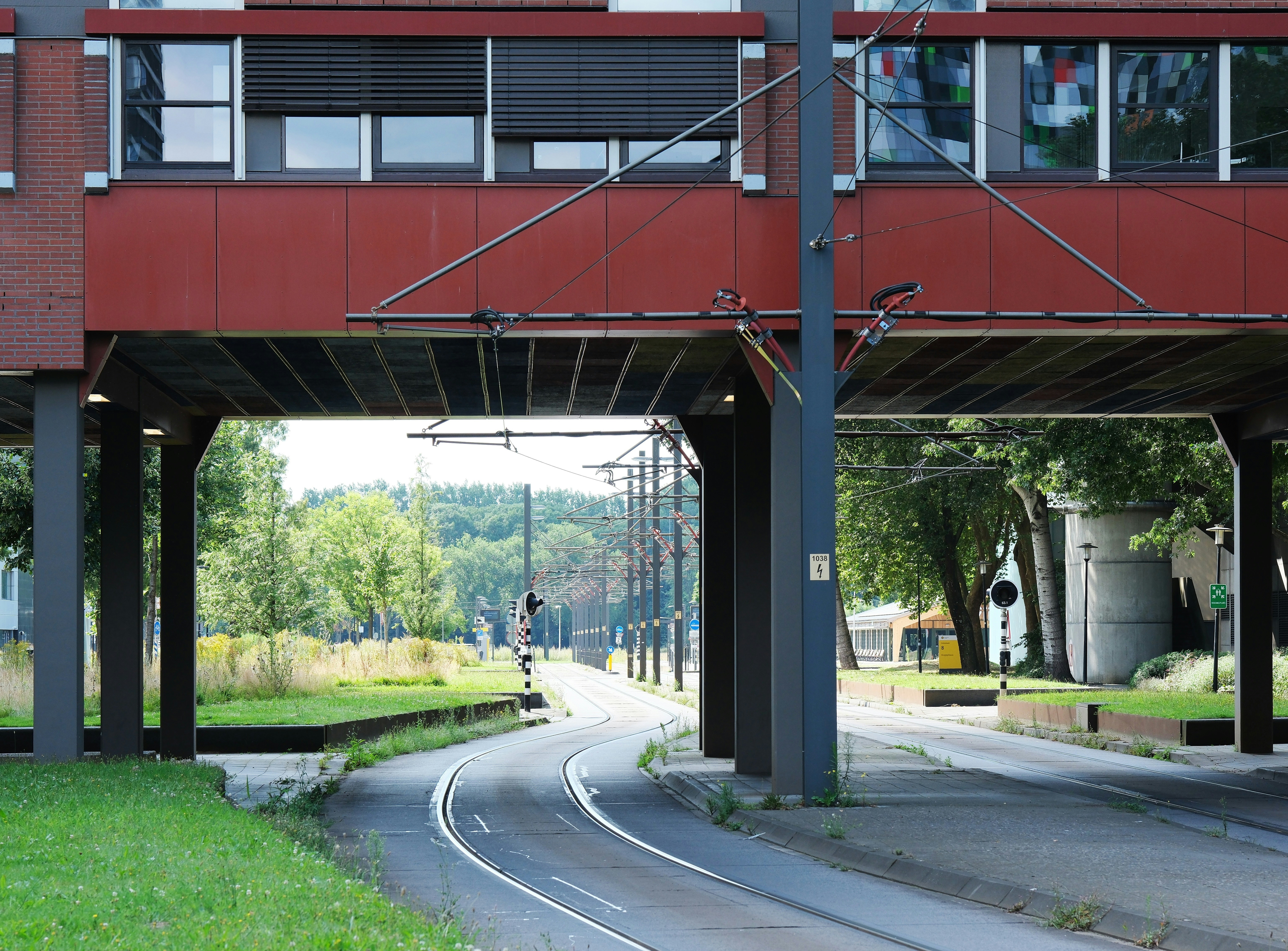Curve of Rails Beneath a Red-Brick Overpass: A Quiet Urban Corridor