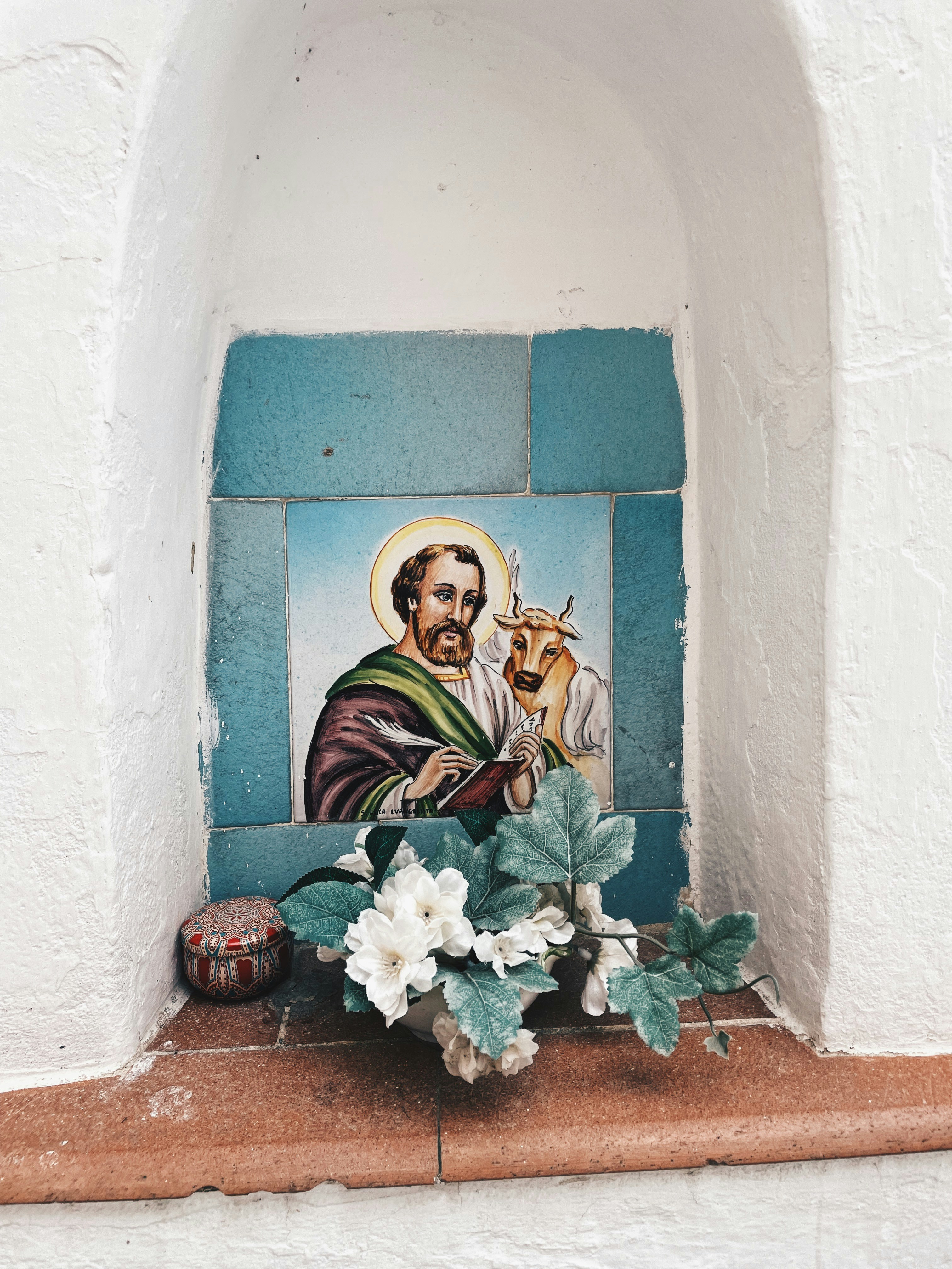 Saint in a Blue Tile Niche: A Quiet Shrine Framed by White Arch