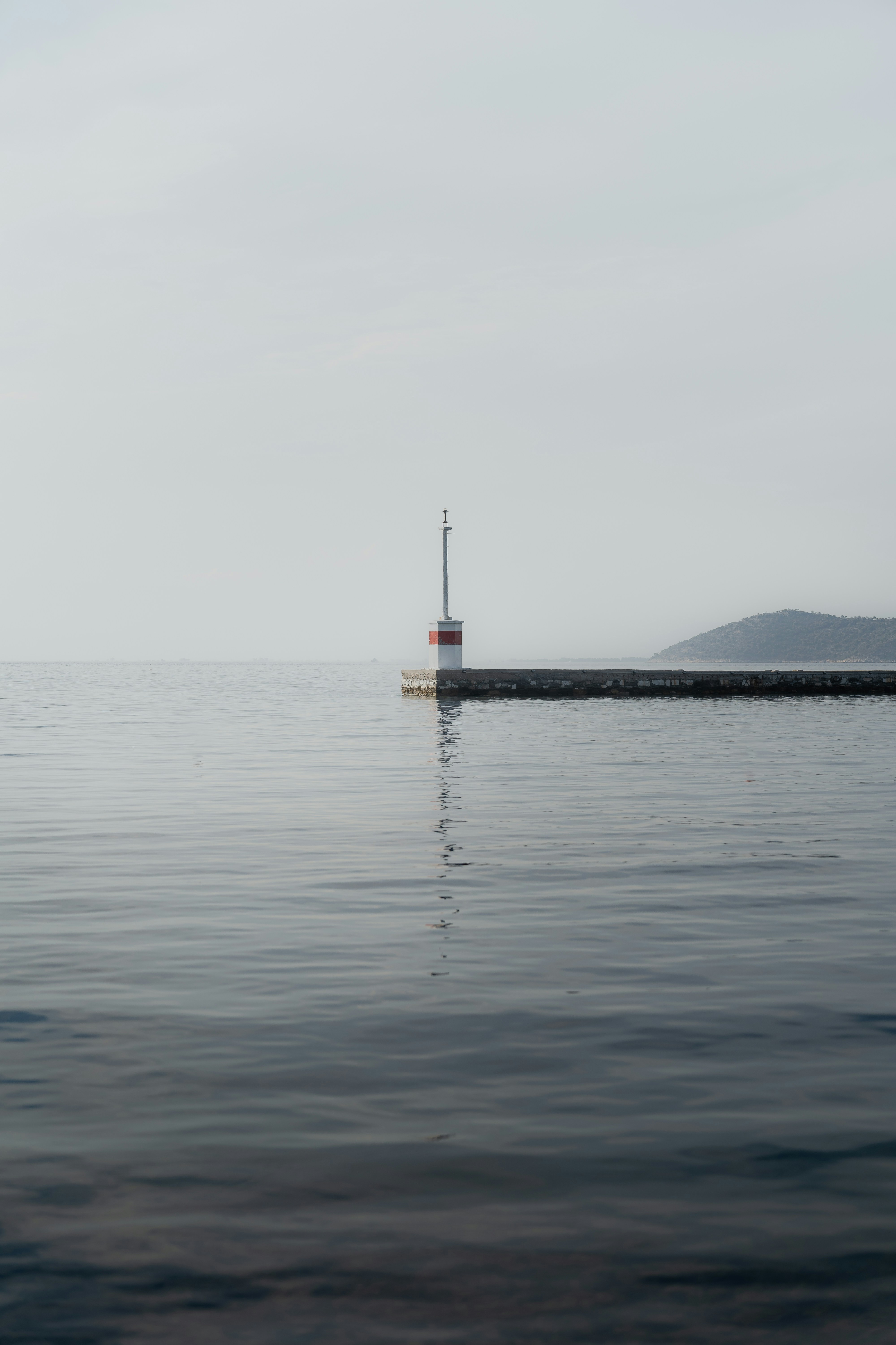 Lone Beacon at the Pier's Edge: A Quiet Harbor Moment
