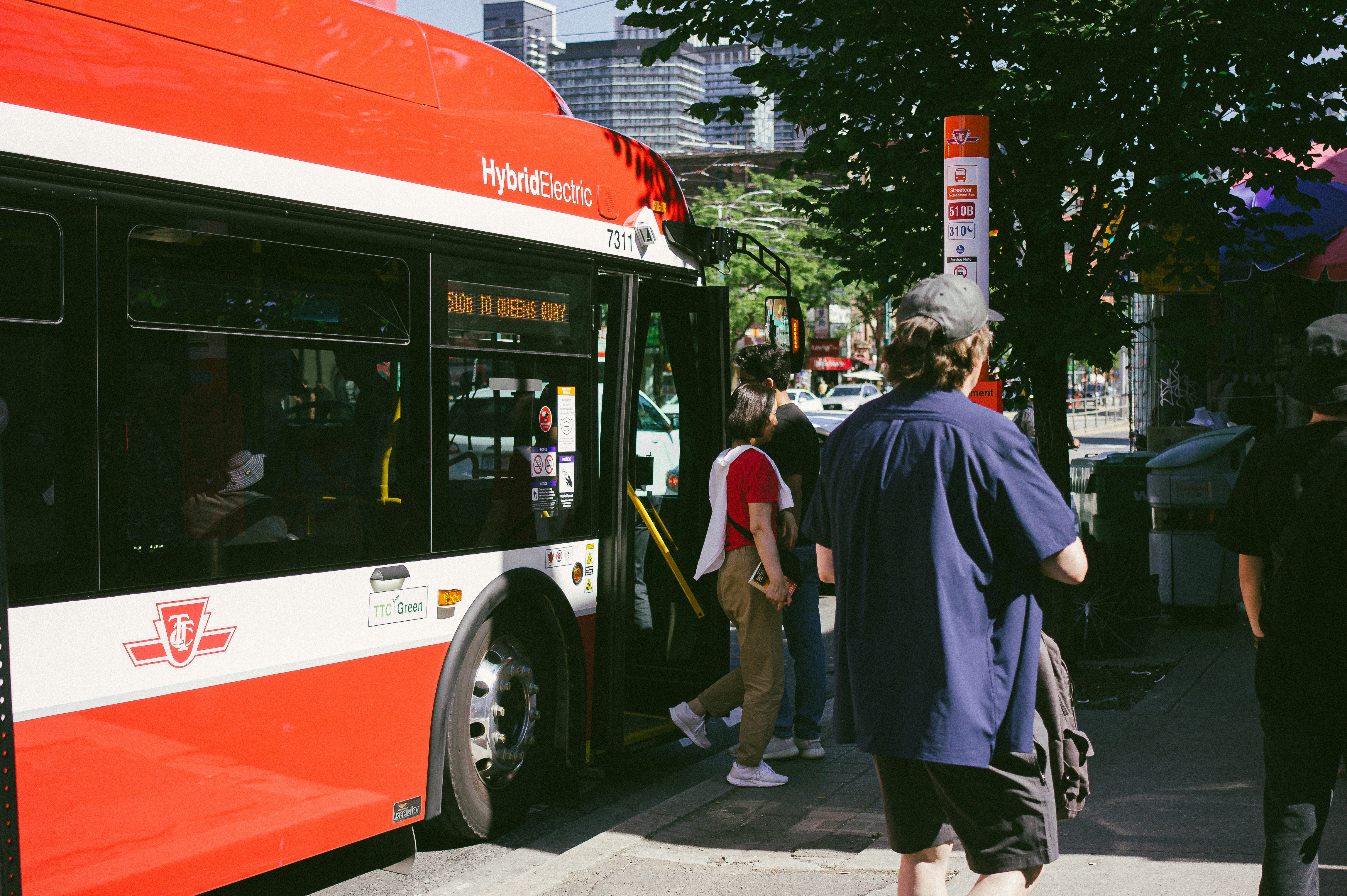 A red and white bus parked on the side of a street photo – Free Toronto ...