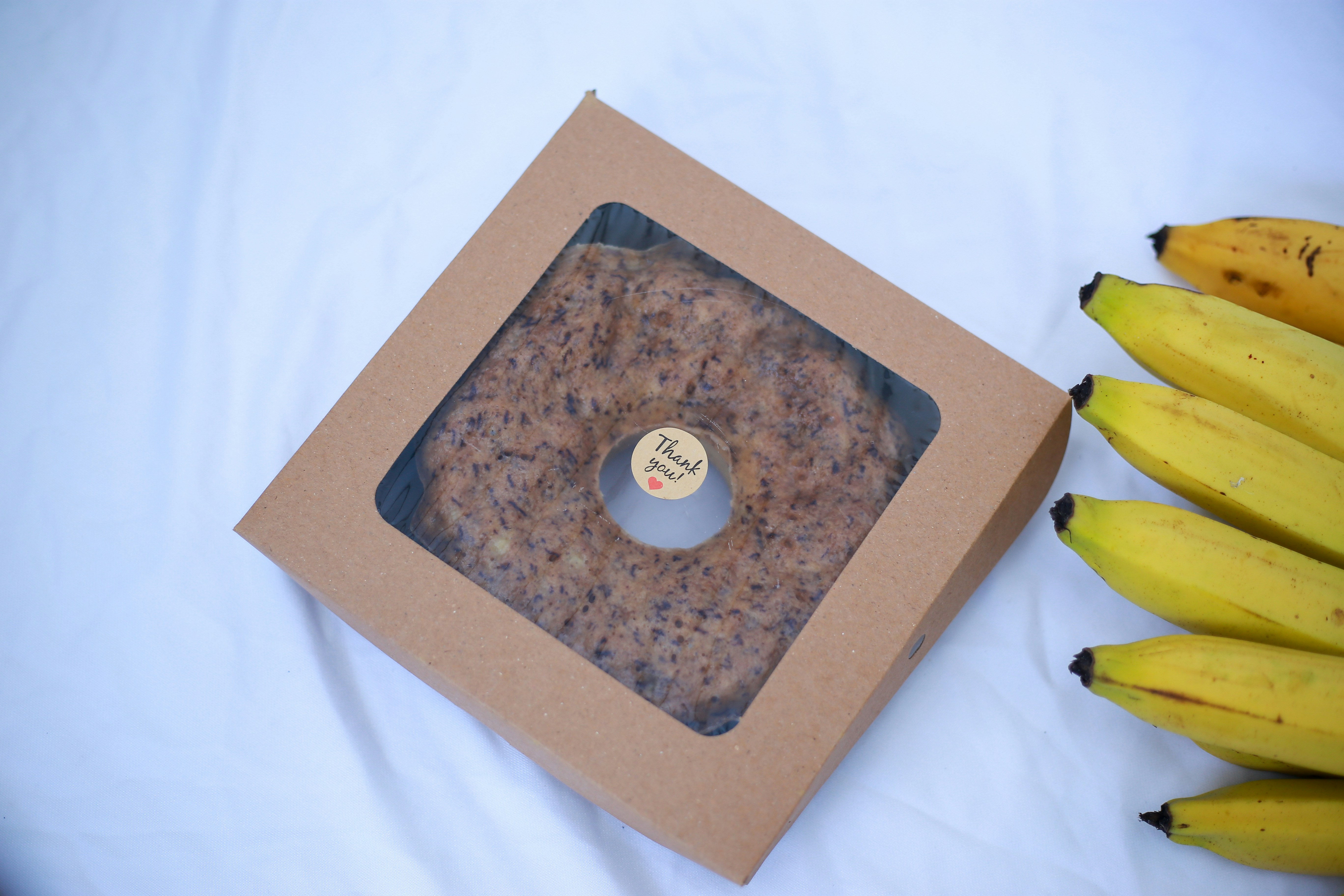 Una caja de cartón con un botón junto a un racimo de plátanos foto ...
