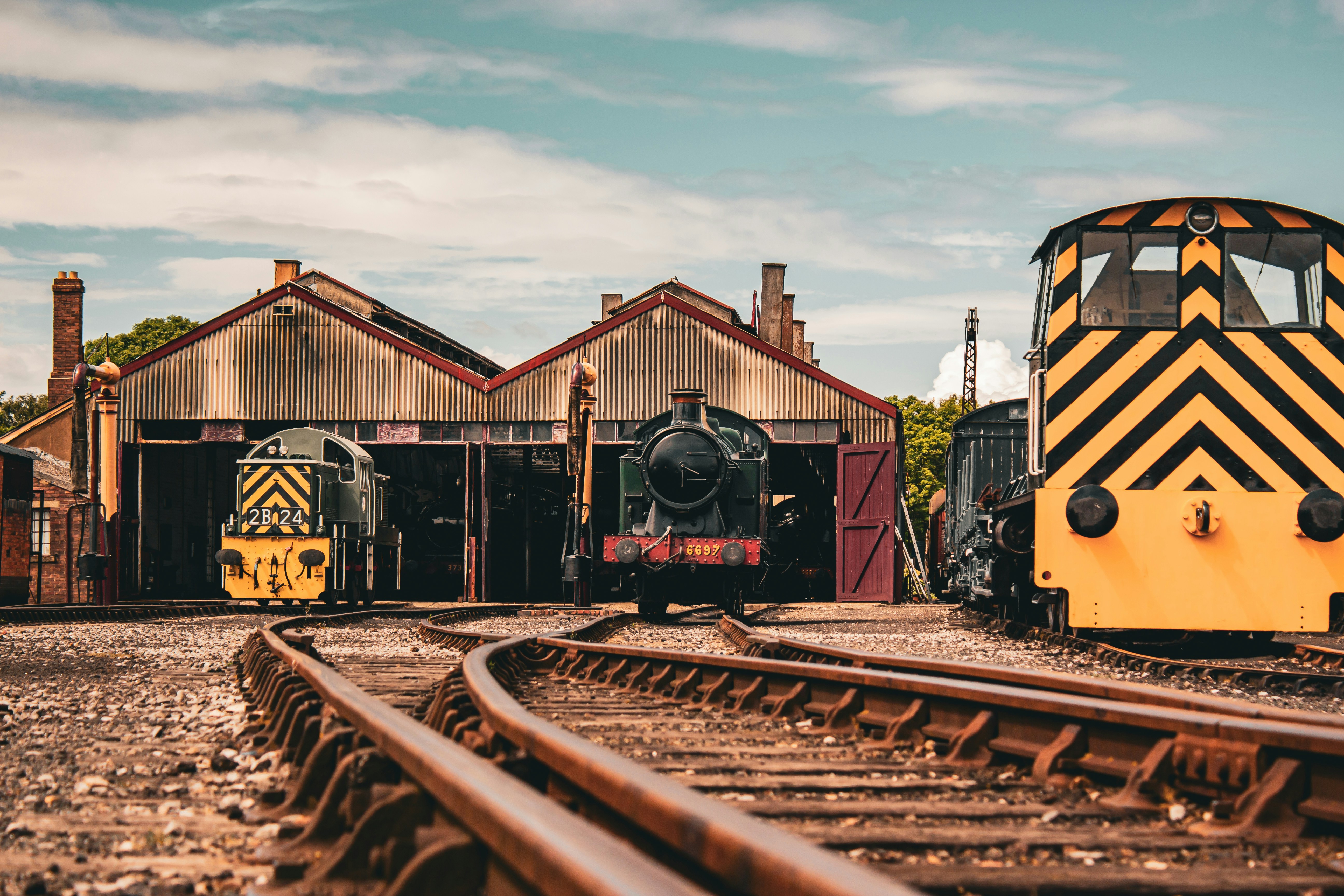A train sitting on top of train tracks next to a building photo – Free ...