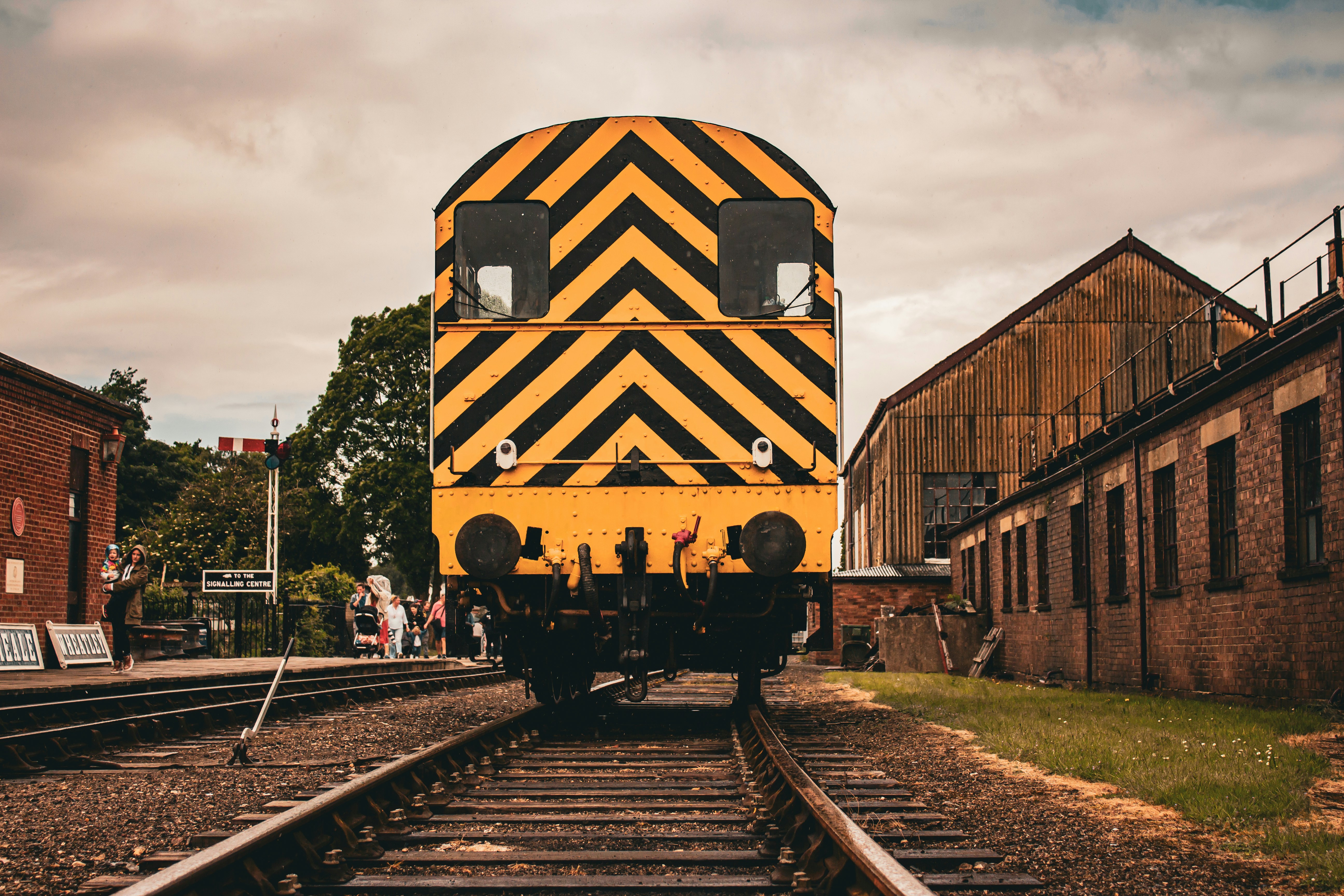 A yellow and black train traveling down train tracks photo – Free Rail Image on Unsplash