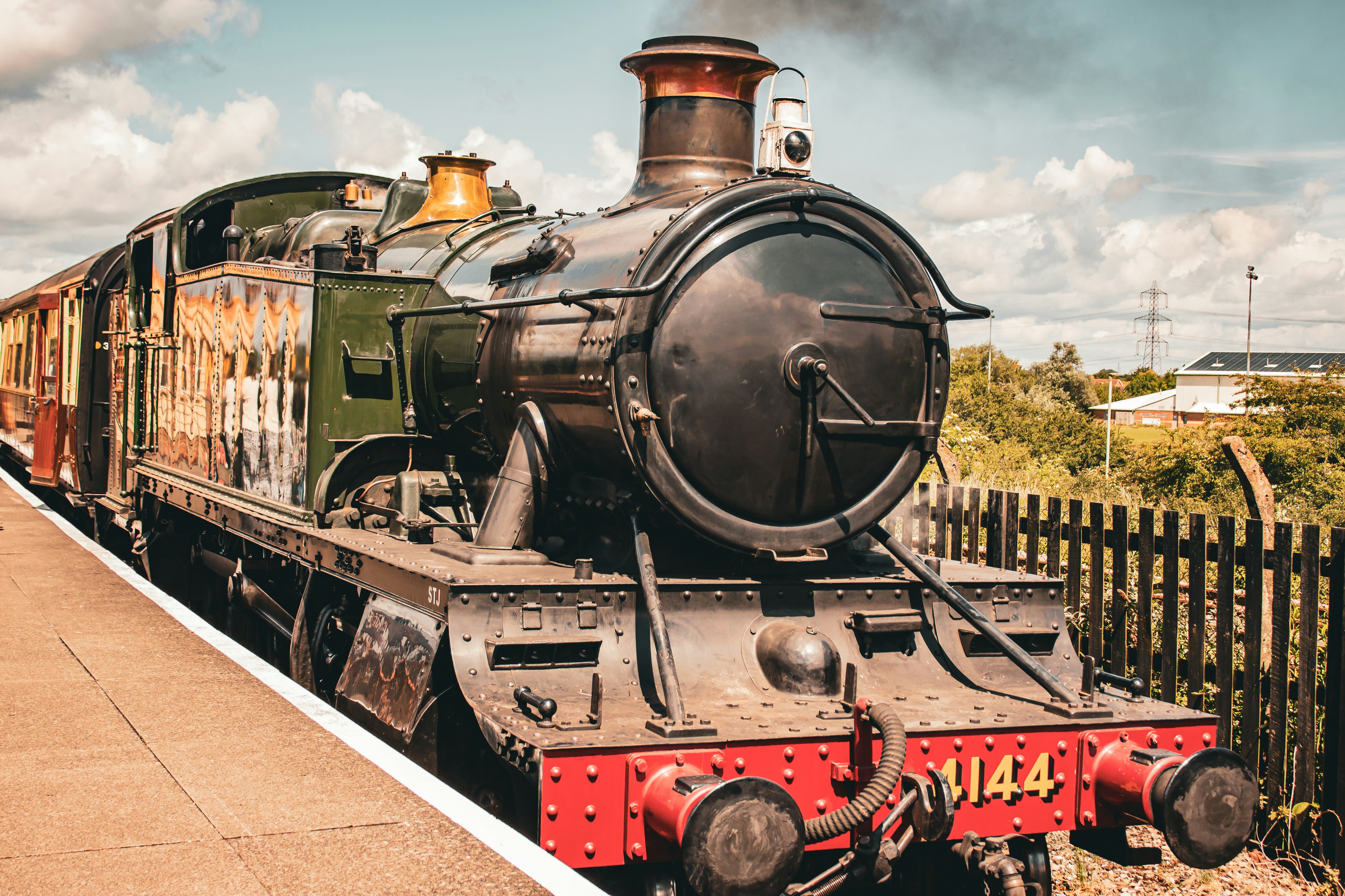 A steam engine train traveling down train tracks photo – Free ...