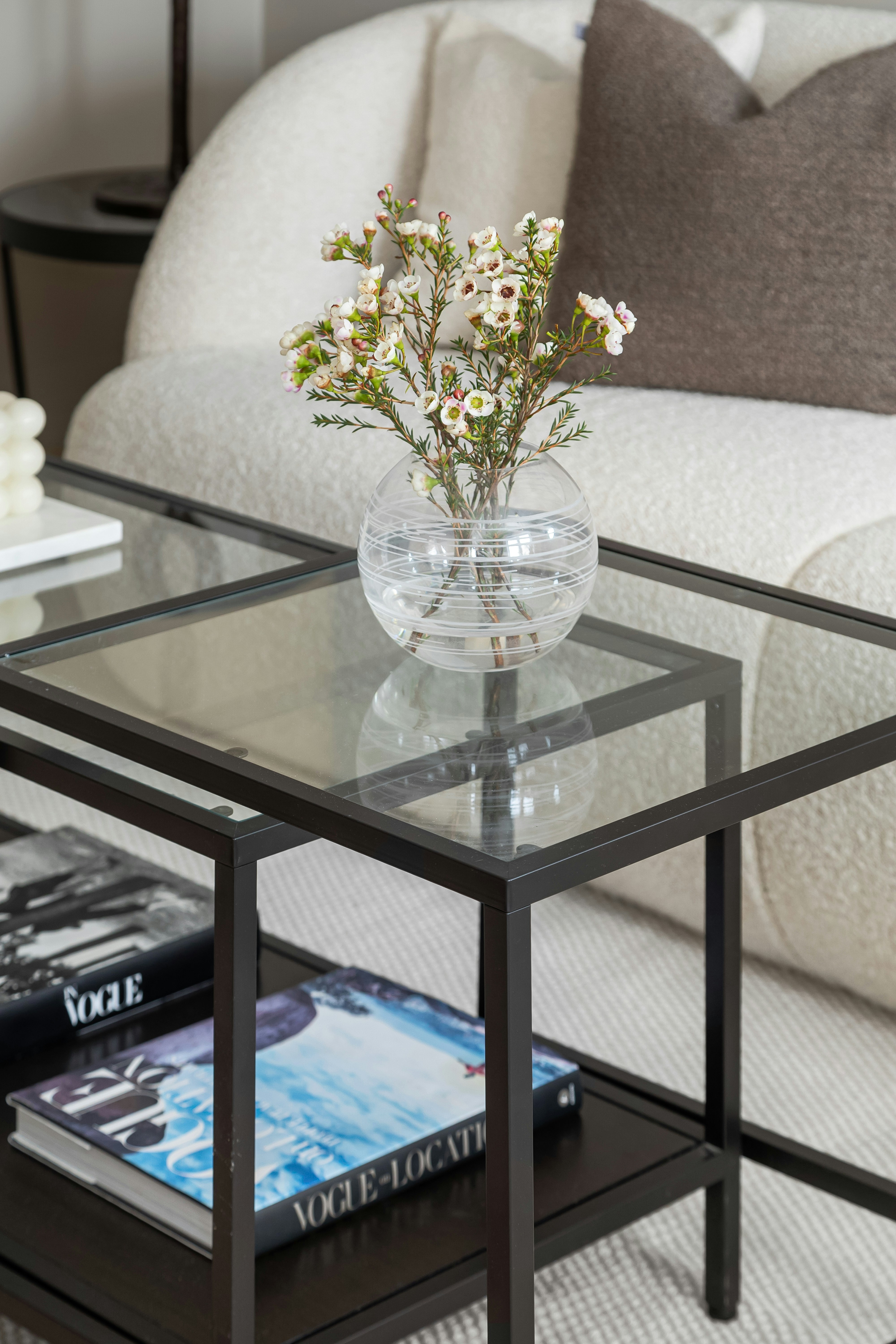 A glass table with a vase of flowers on top of it