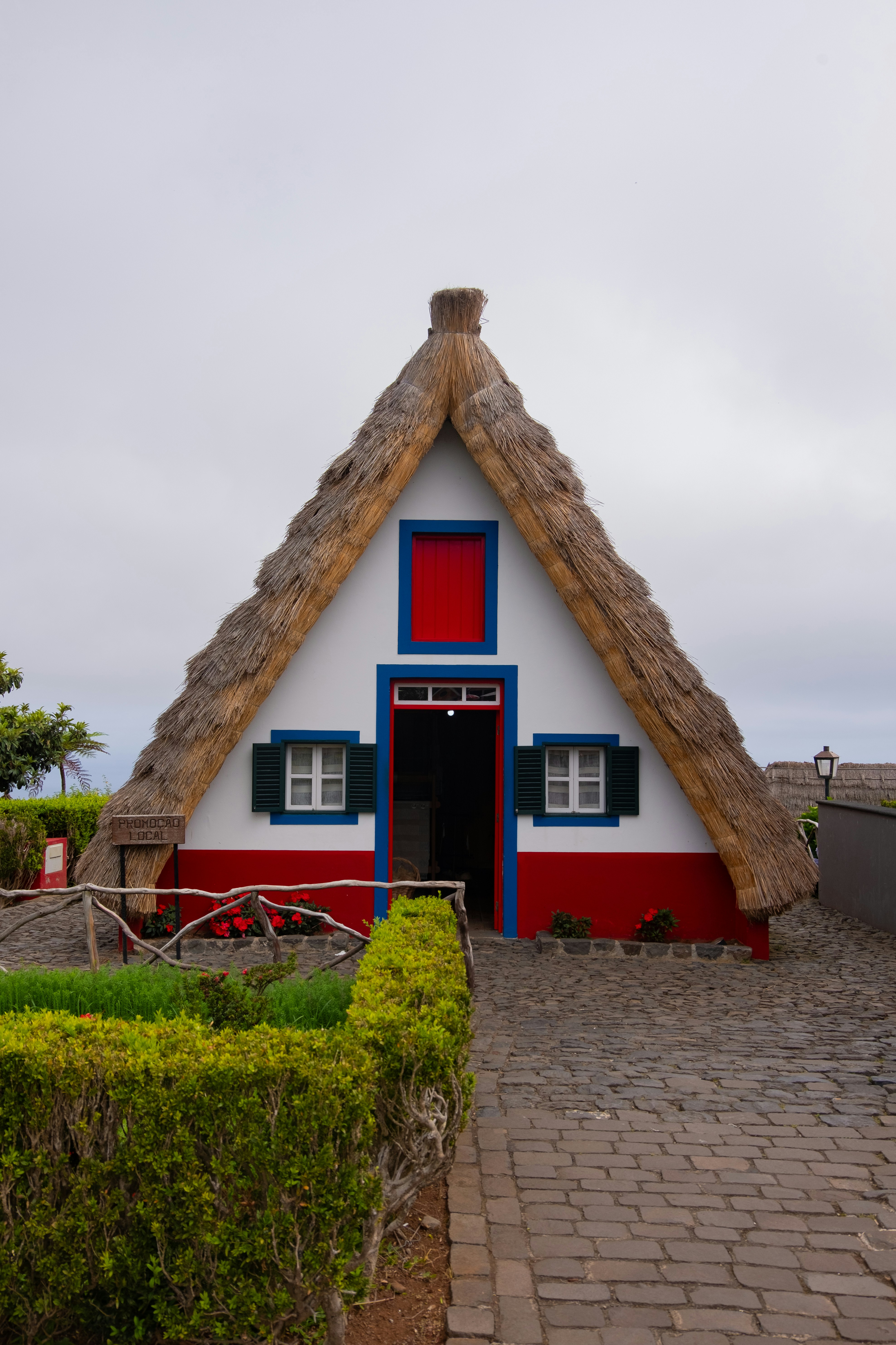 A house with a thatched roof and red, white, and blue trim photo – Free ...