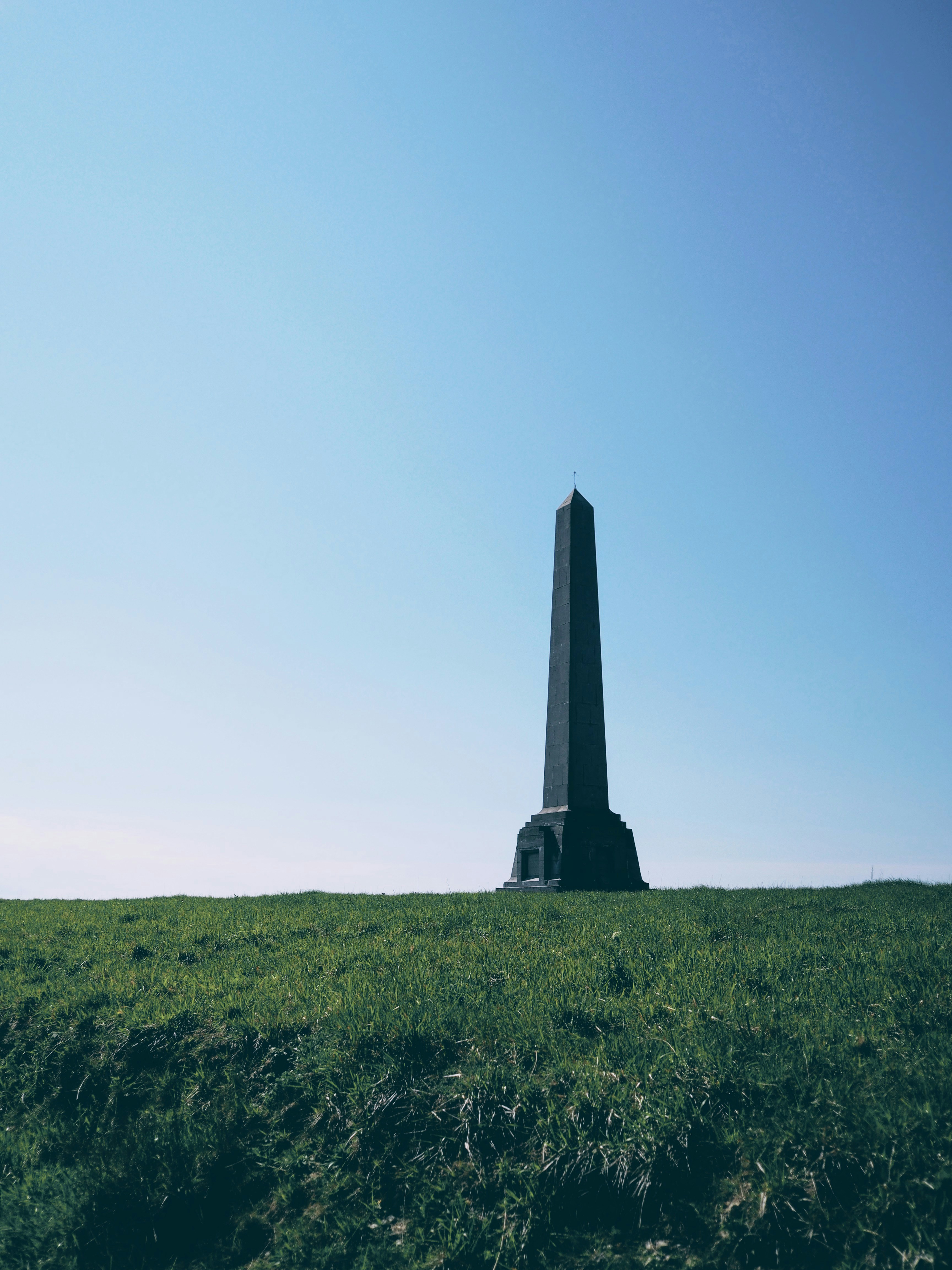 A tall obelisk sitting on top of a lush green field photo – Free Beach ...