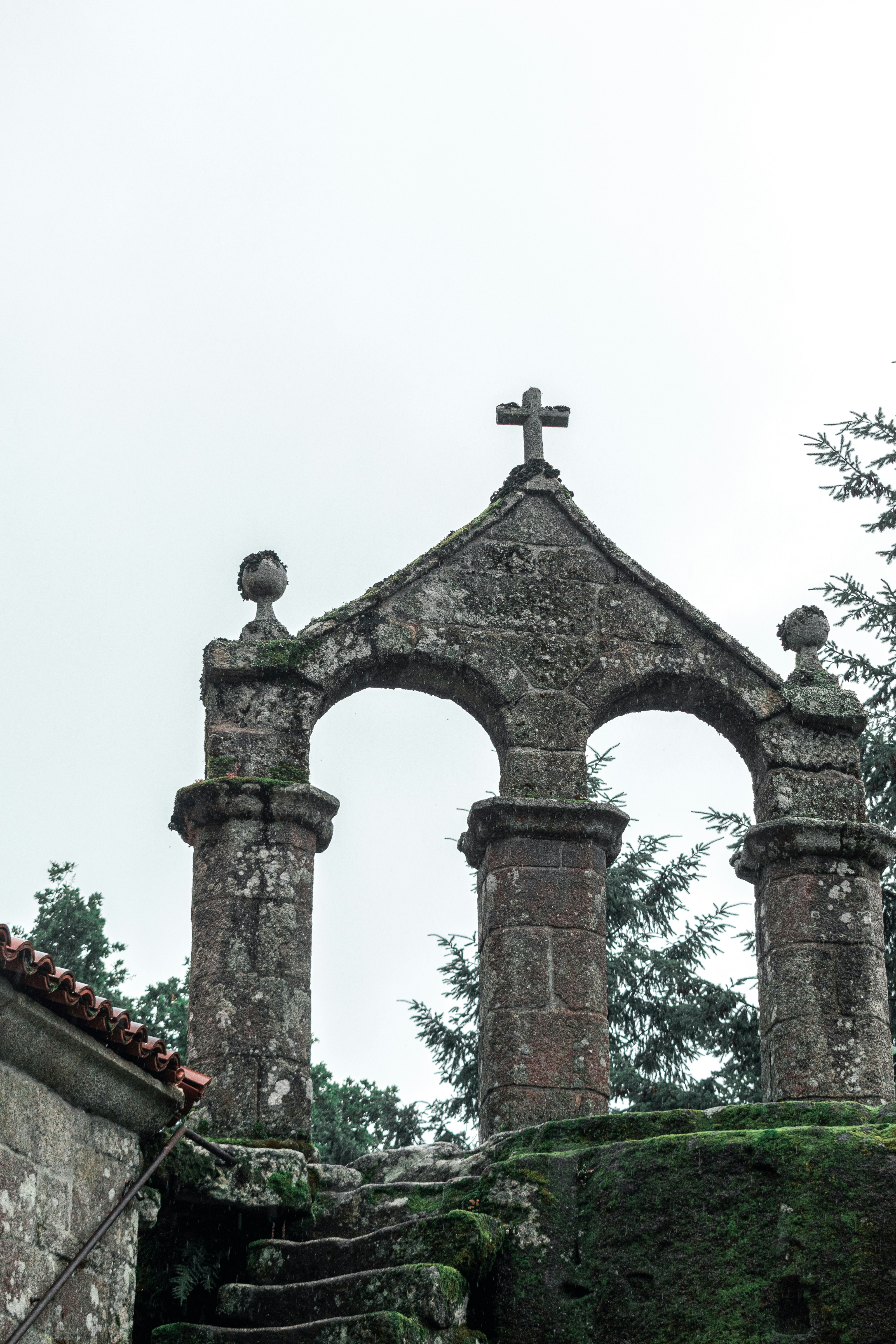 Cross-Topped Archway Rising from Mossy Ruins