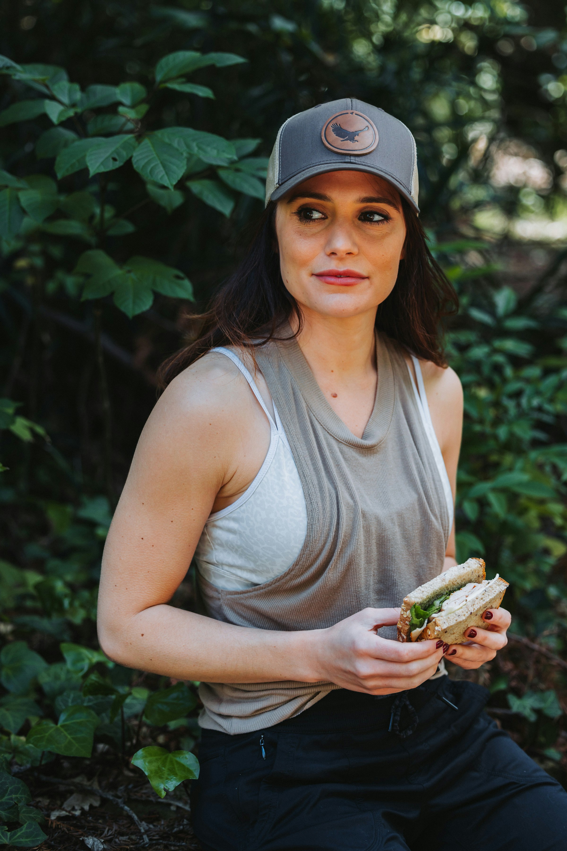 A woman sitting on the ground eating a sandwich photo – Free Sandwich ...