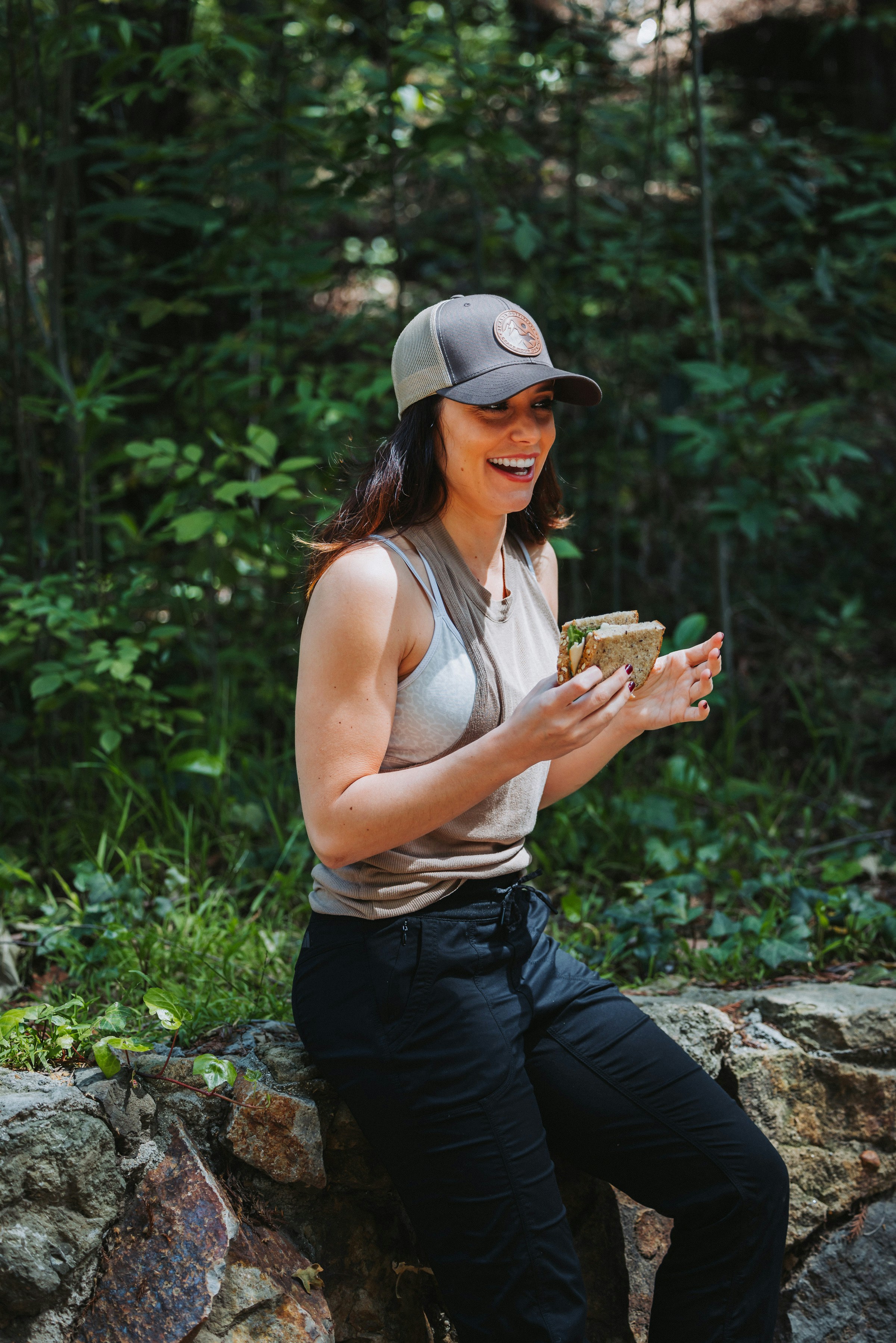 Photography by Ryan Hartford / Ecliptic Media Photography. Woman wearing our heat-pressed leather patch trucker hat in the forest during a nature hike. Leather patch hat from Byward Outfitters www.bywardoutfitters.com