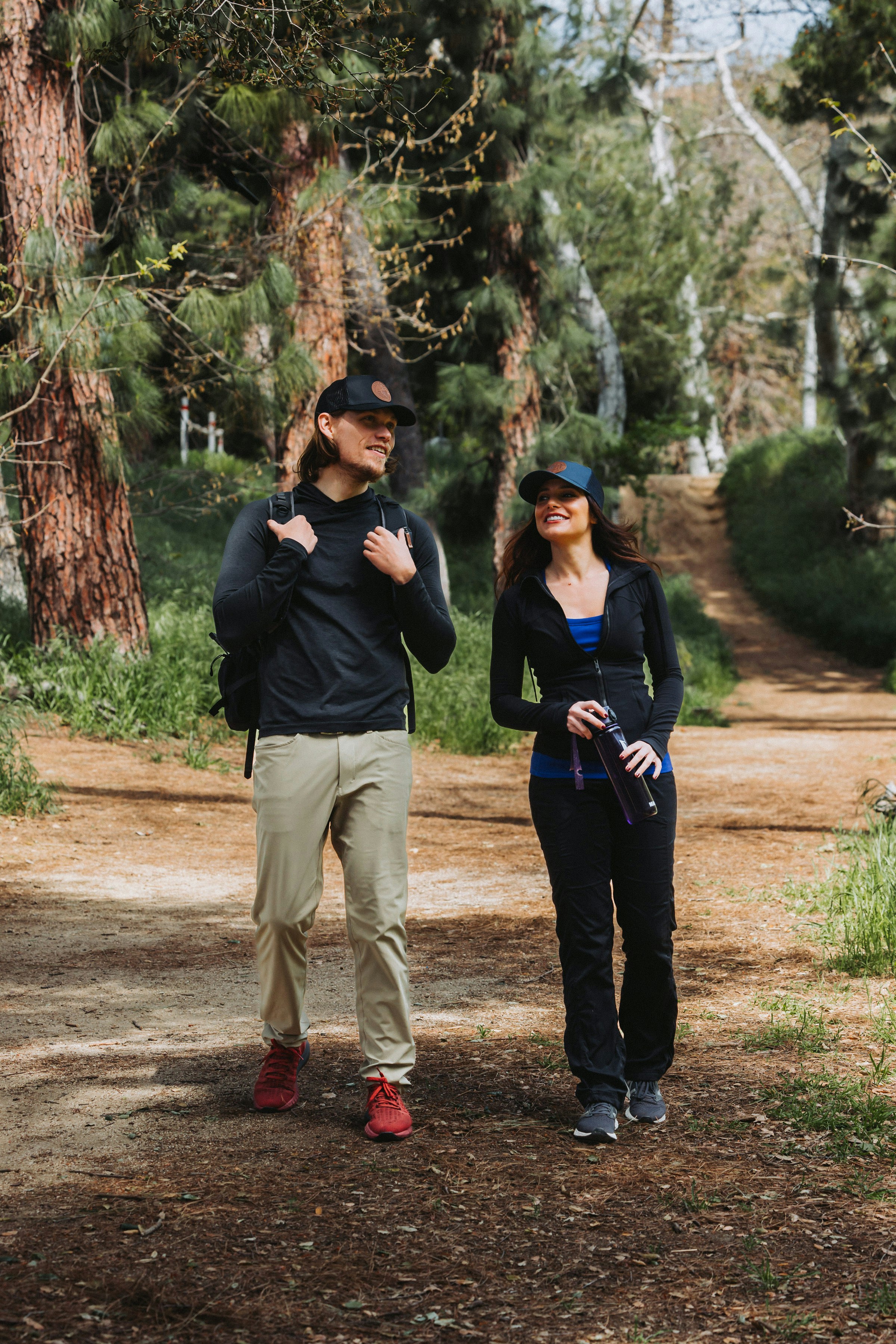 Photography by Ryan Hartford / Ecliptic Media Photography. Woman wearing our heat-pressed leather patch trucker hat in the forest during a nature hike. Leather patch hat from Byward Outfitters www.bywardoutfitters.com