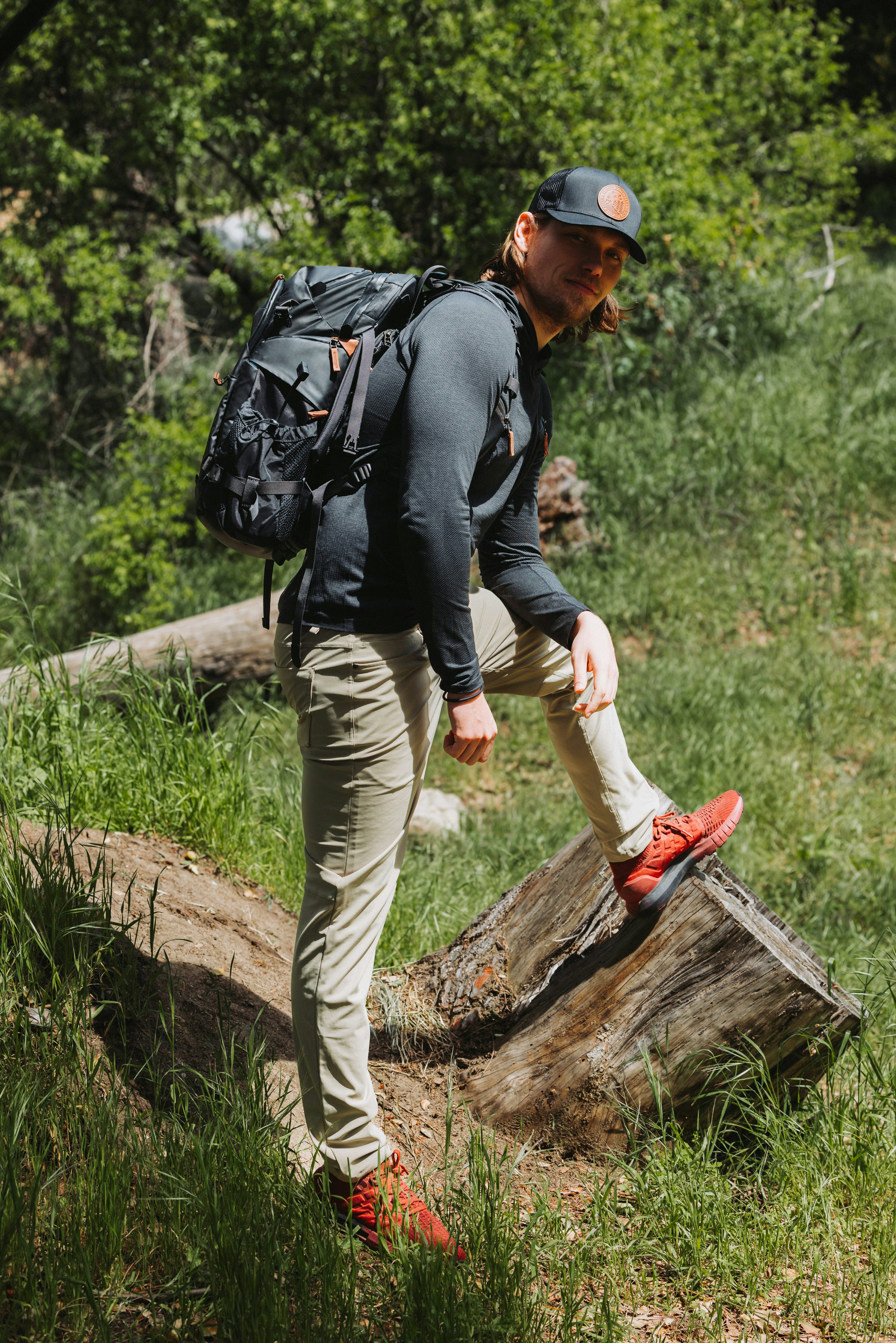 Photography by Ryan Hartford / Ecliptic Media Photography. Woman wearing our heat-pressed leather patch trucker hat in the forest during a nature hike. Leather patch hat from Byward Outfitters www.bywardoutfitters.com
