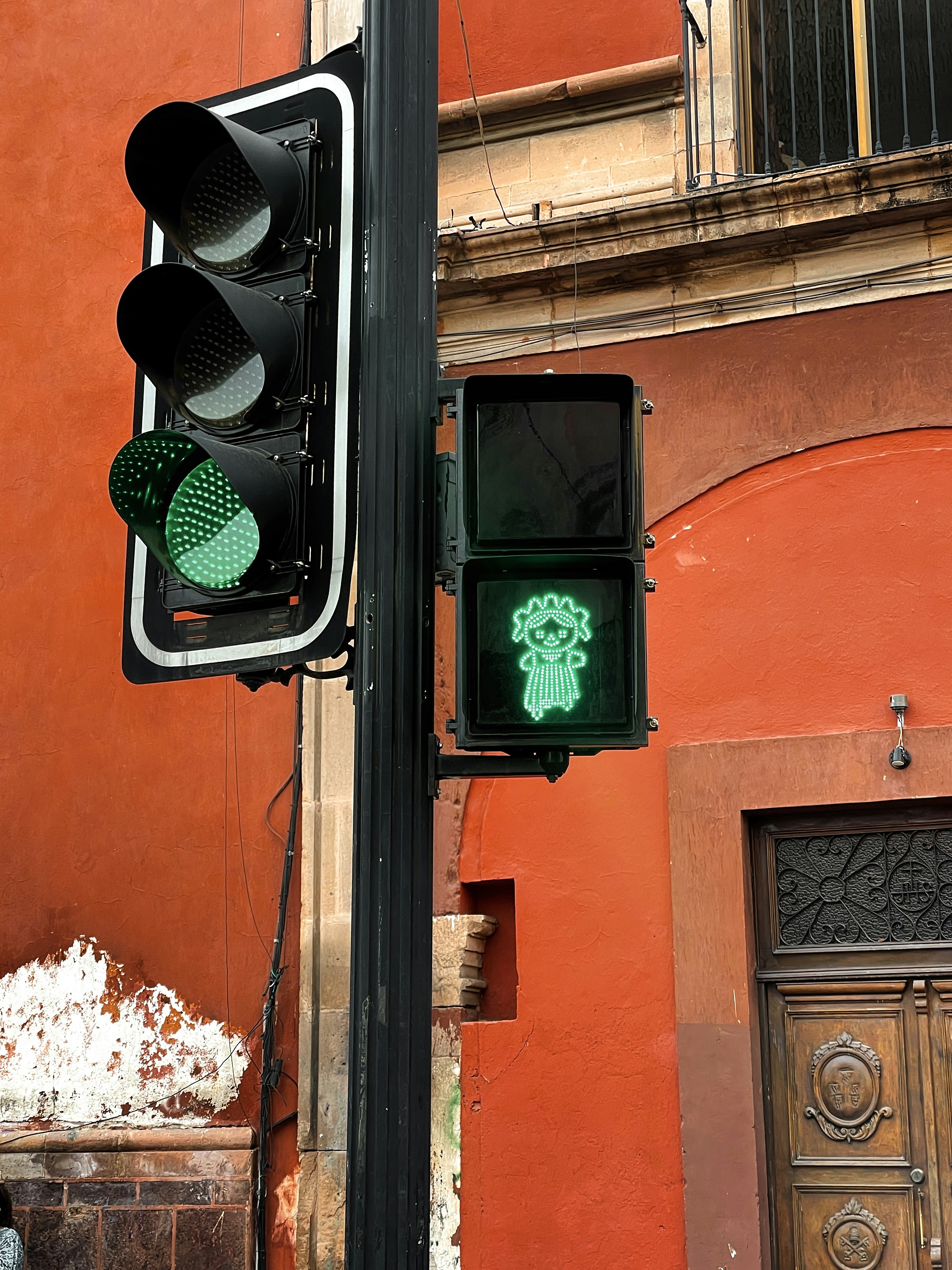 Green Neon Pedestrian Signal Framed by a Warm Urban Façade