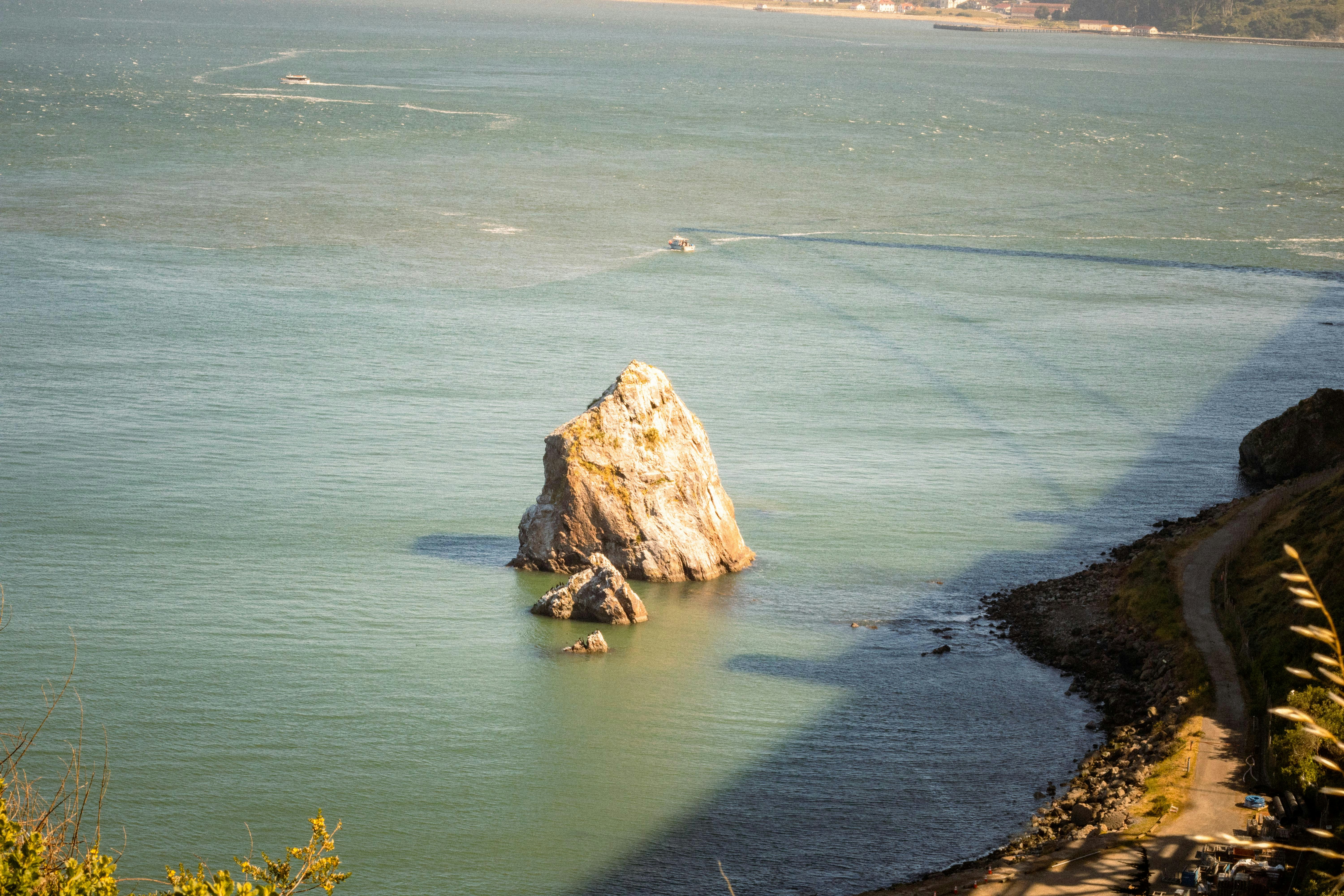 Stone Sentinel Over Turquoise Waters Along a Cliffside Path