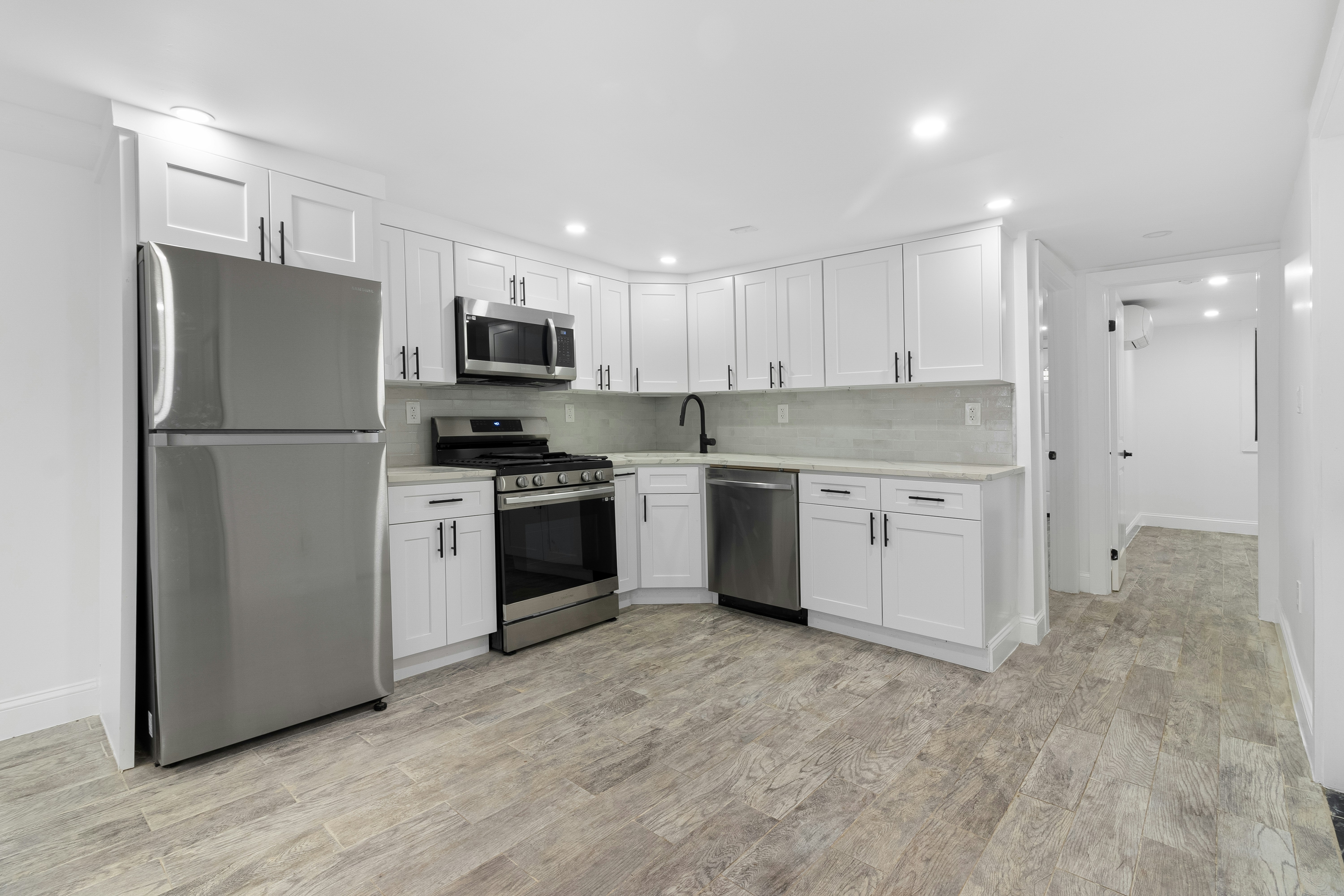 A kitchen with white cabinets and silver appliances photo – Free ...