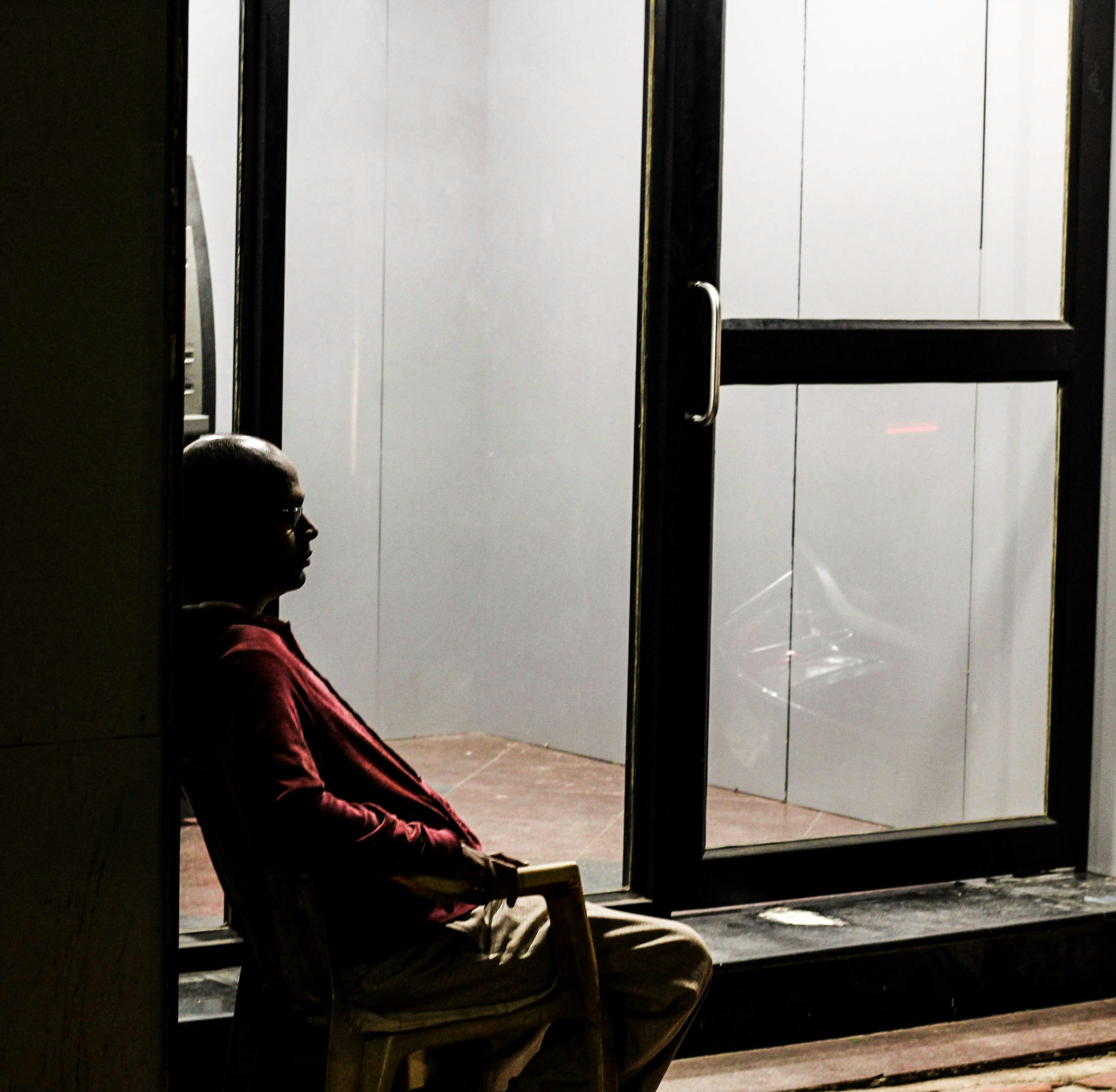 A man sitting in a chair in front of a window