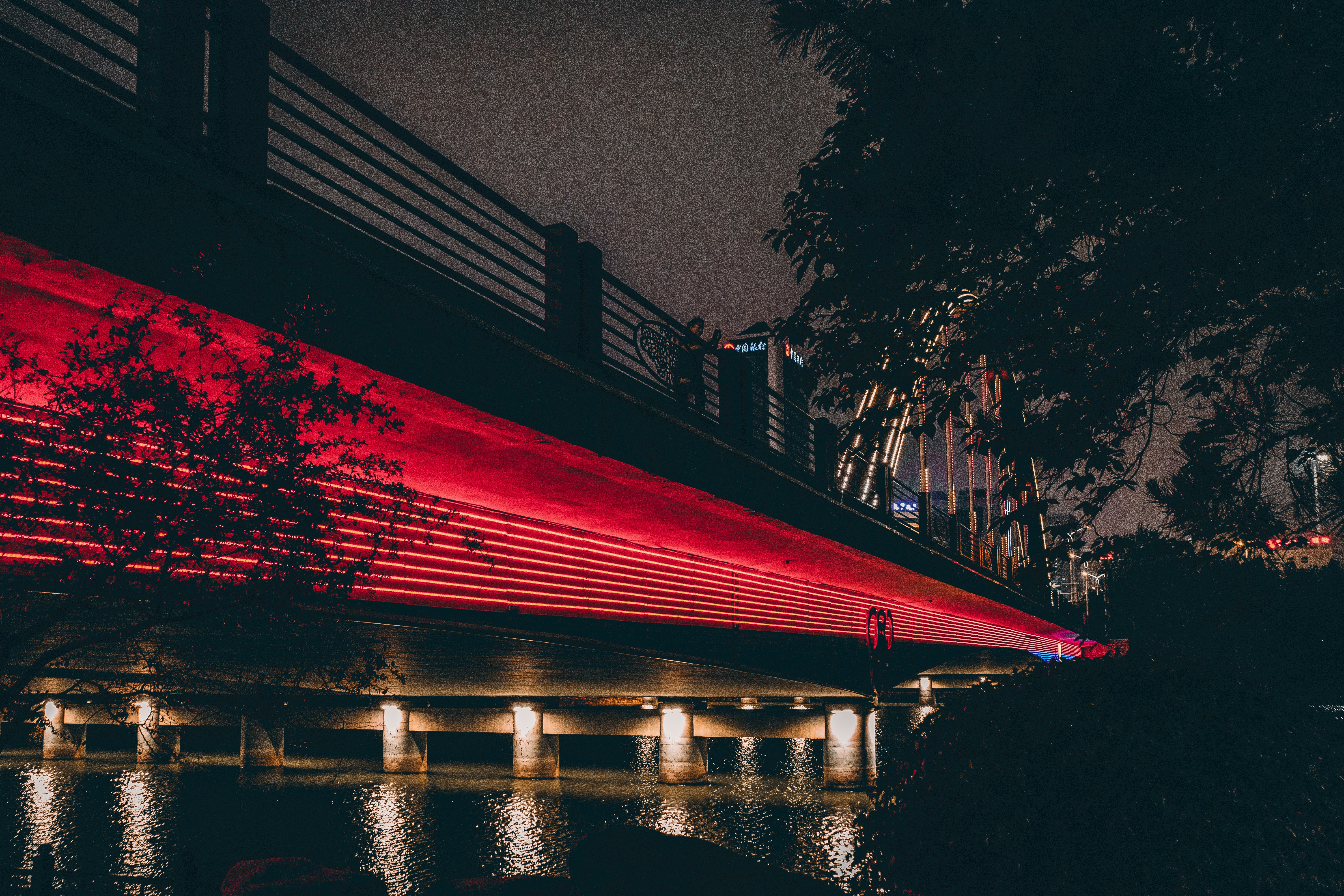 A red light shines on the side of a bridge photo – Free City Image on ...