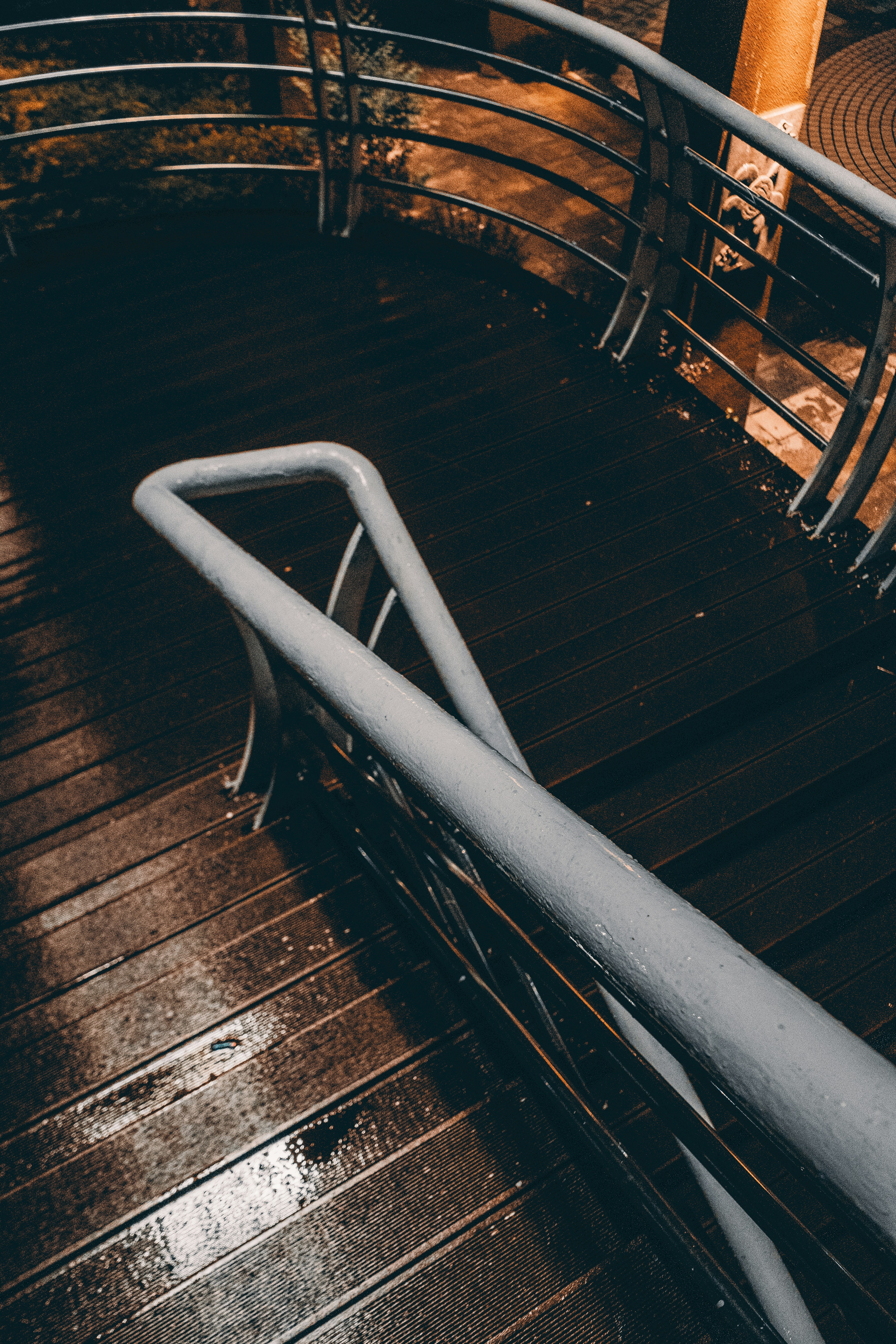 Spiral Night: Wet Railings and Amber Light on a Circular Staircase