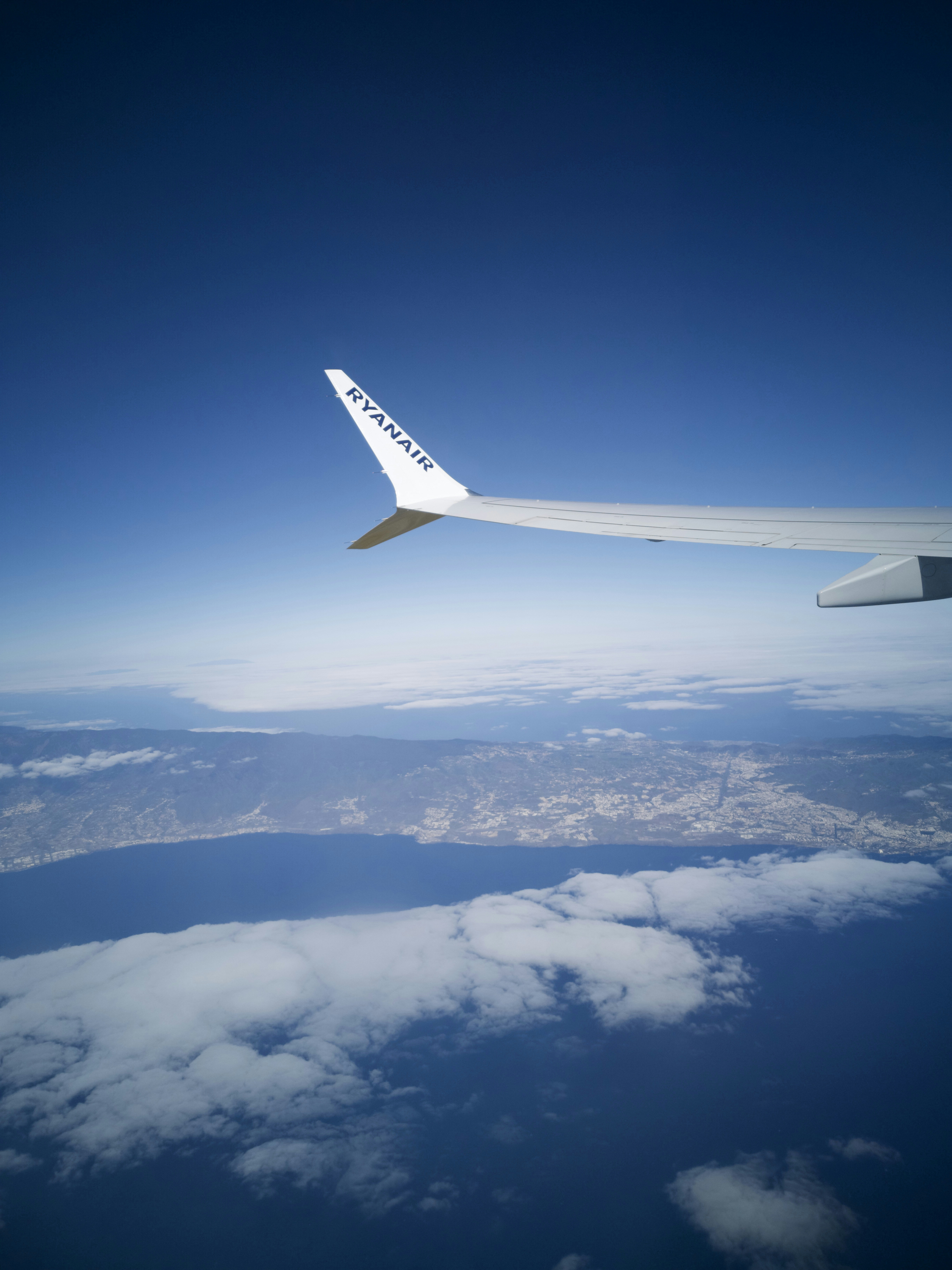 Cerulean Sky and Ryanair Wing: A Quiet Glide Above the Clouds