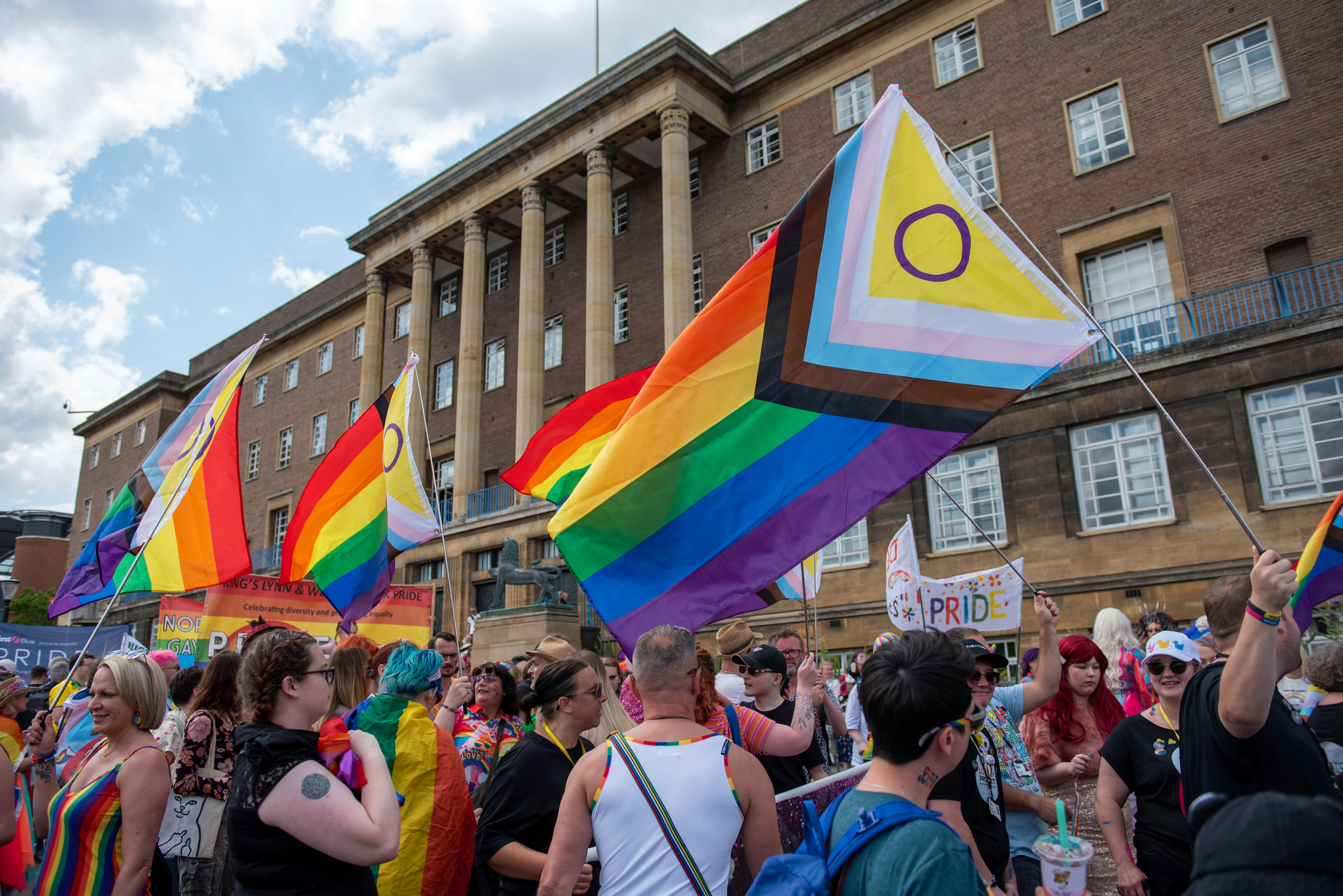 Center-Rainbow Banner Leads the Pride Parade Before a Brick Campus Facade