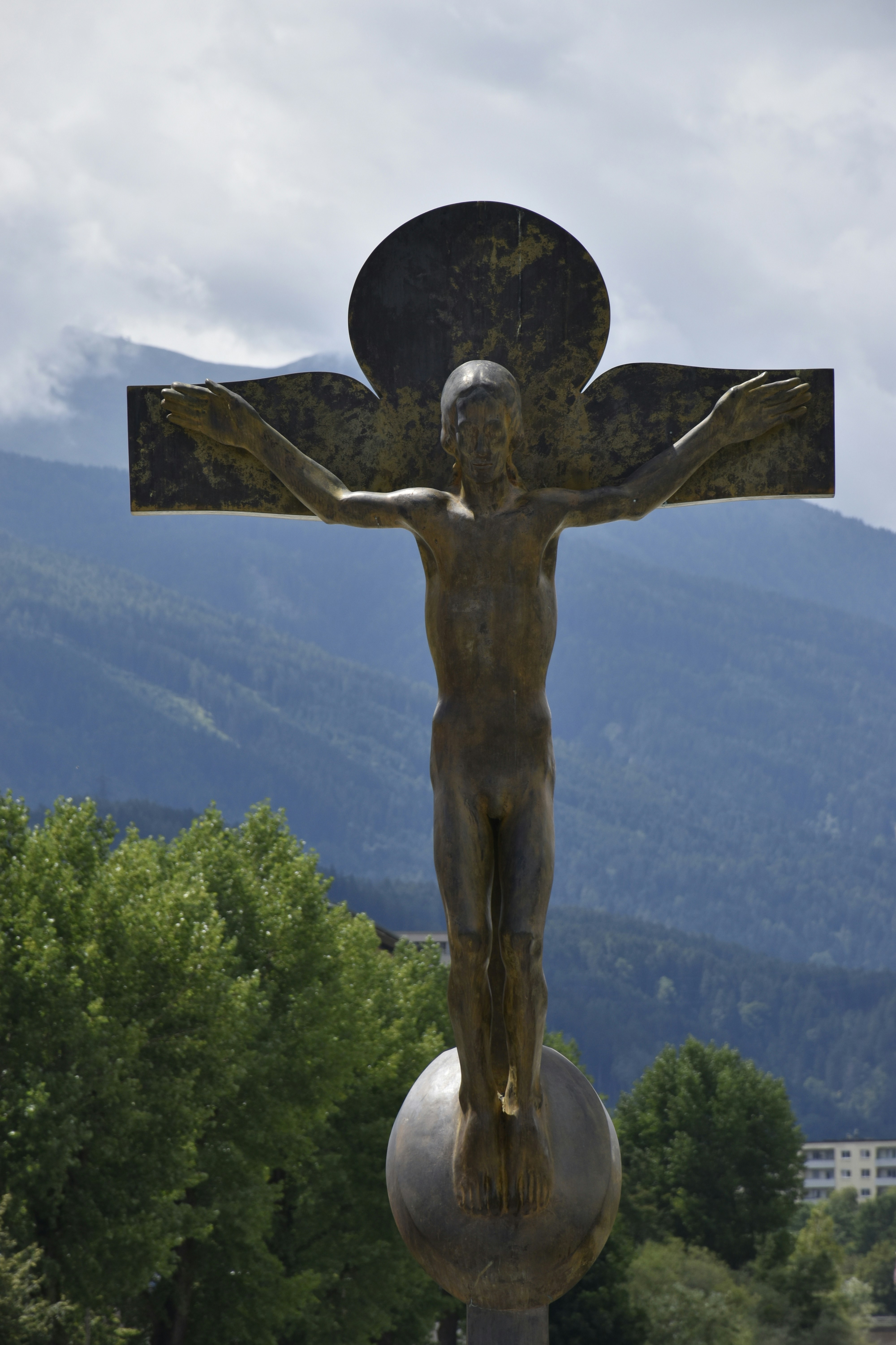 Bronze Crucifix Silhouette Framed by Alpine Sky