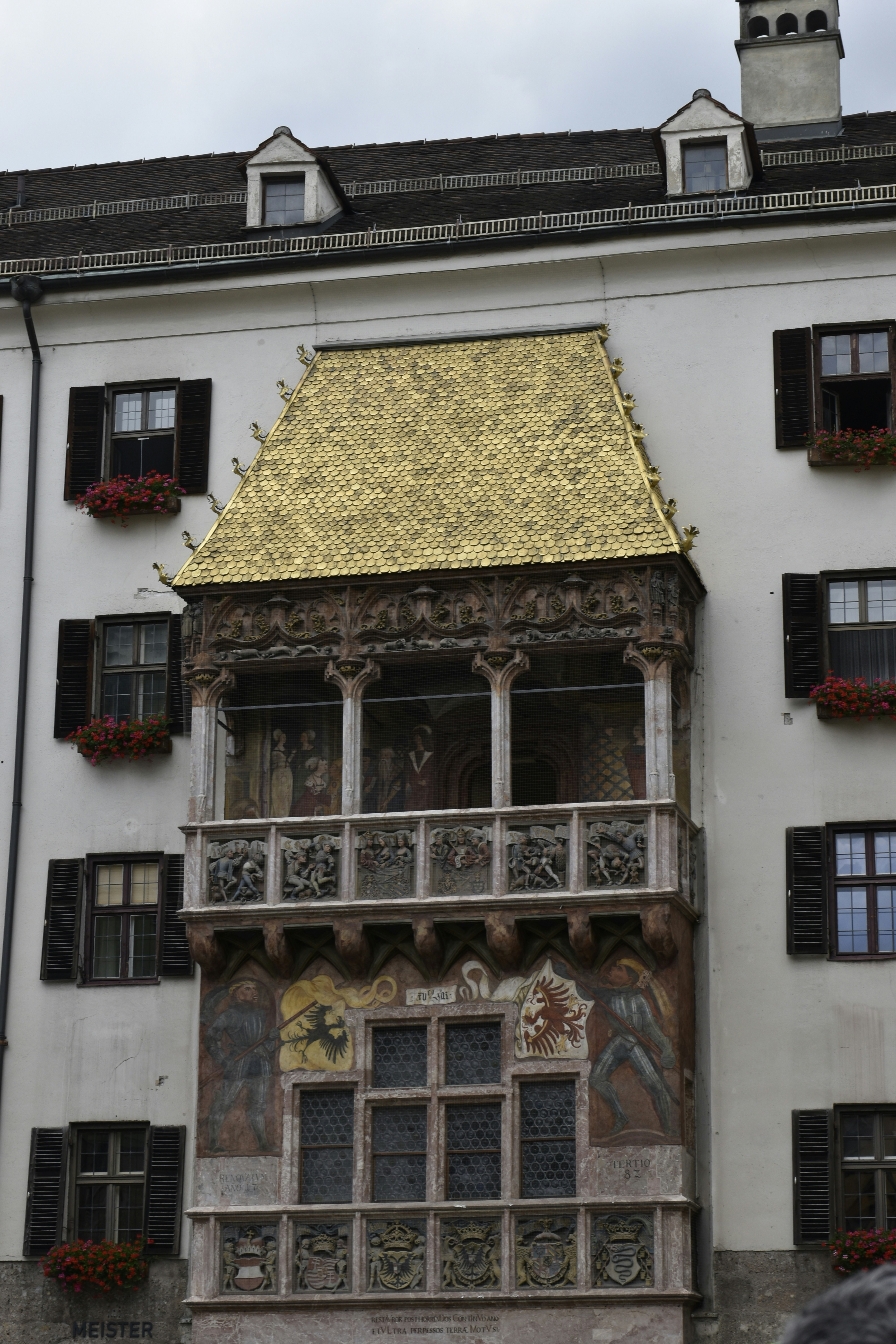 Gilded Roof Over Painted Balcony: A Medieval Facade in Focus