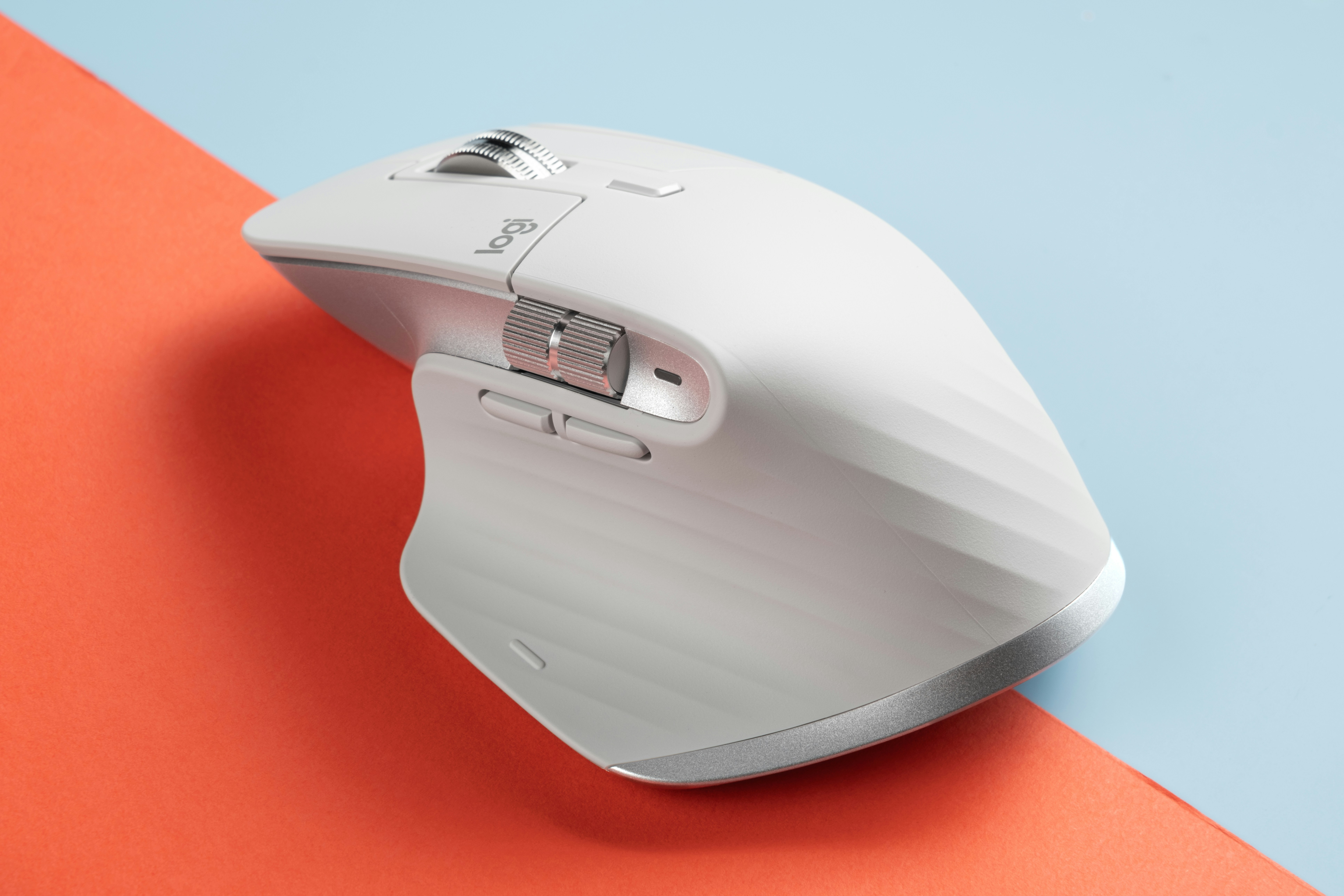 A computer mouse sitting on top of a red and blue surface photo – Free ...