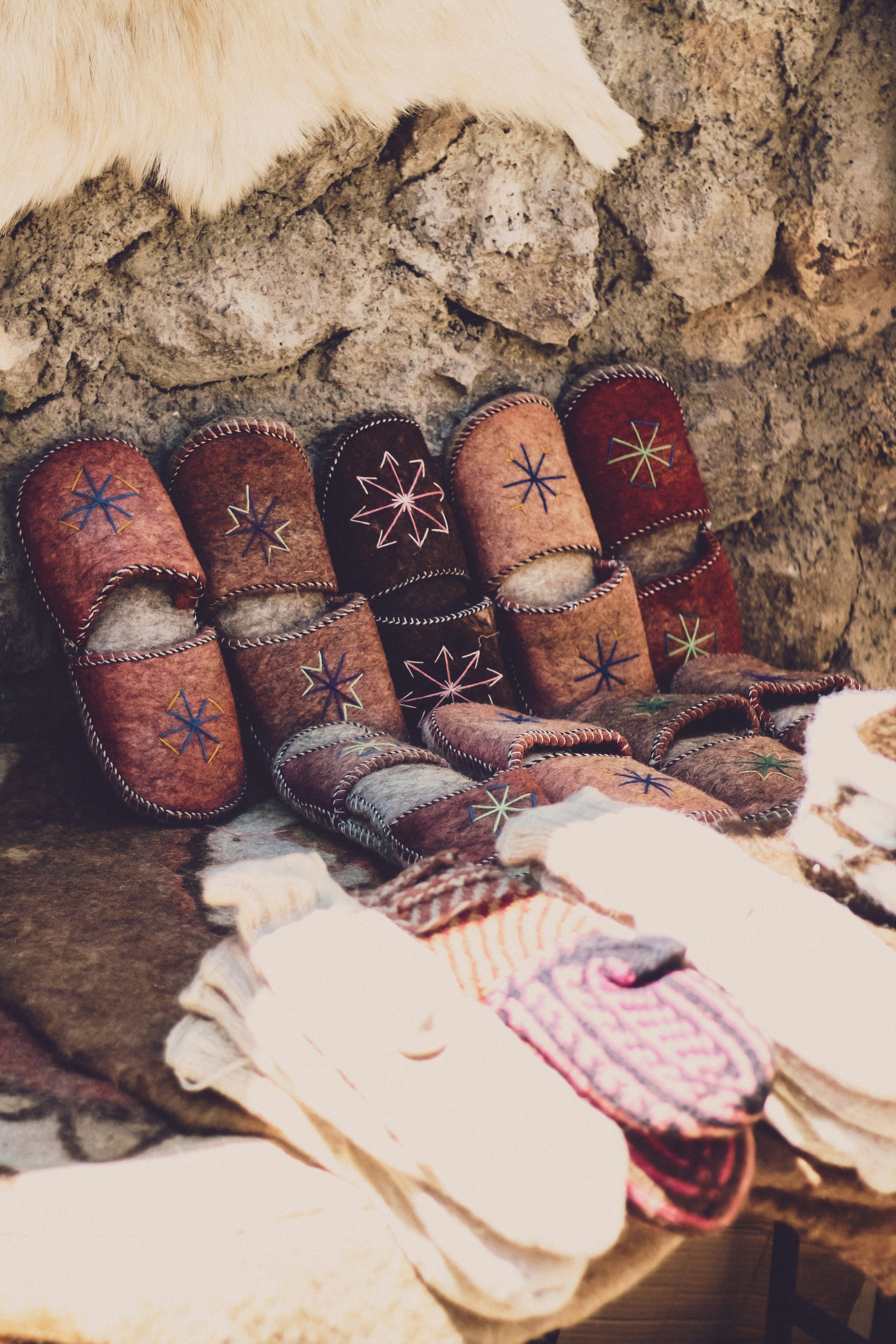 Embroidered Slippers Resting Against Stone: Textile Stars in a Cozy Display