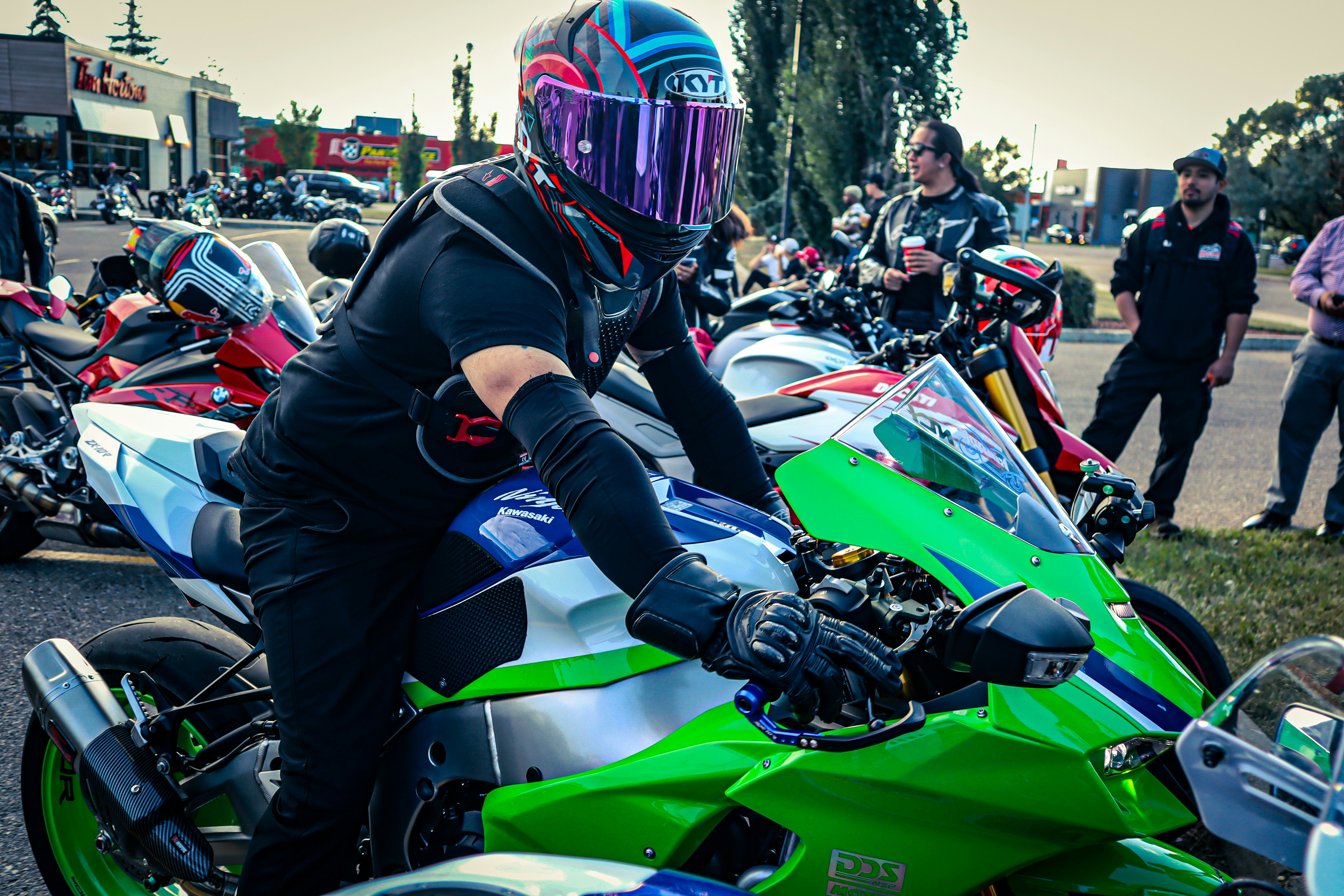 A group of motorcyclists parked in a parking lot photo – Free Helmet ...