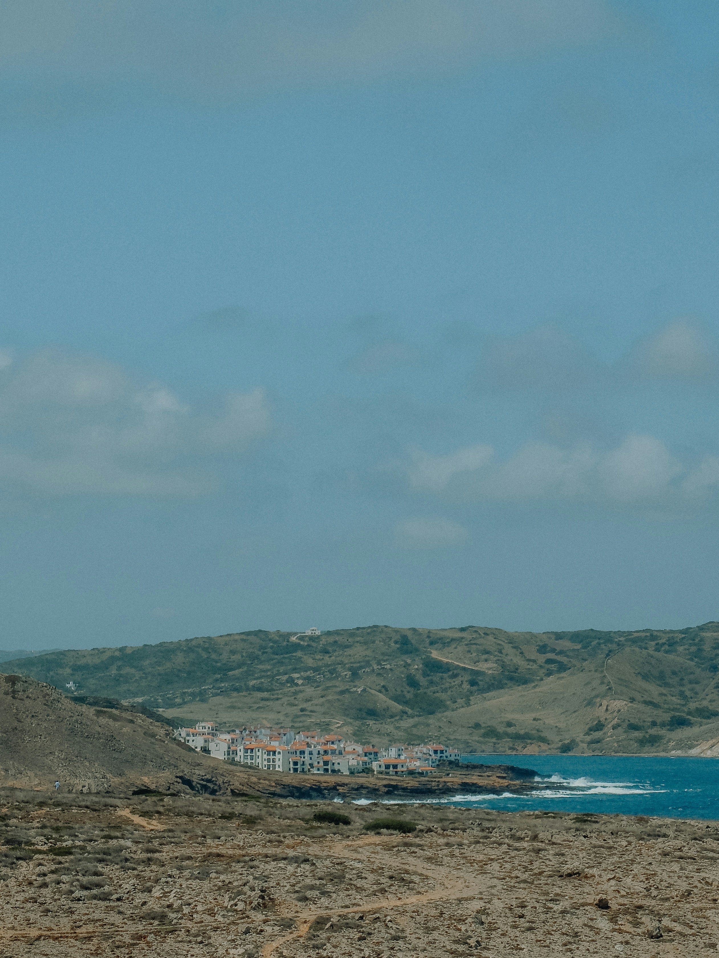 Harbor Crescent: White-Washed Village Nestled Along a Rocky Coast