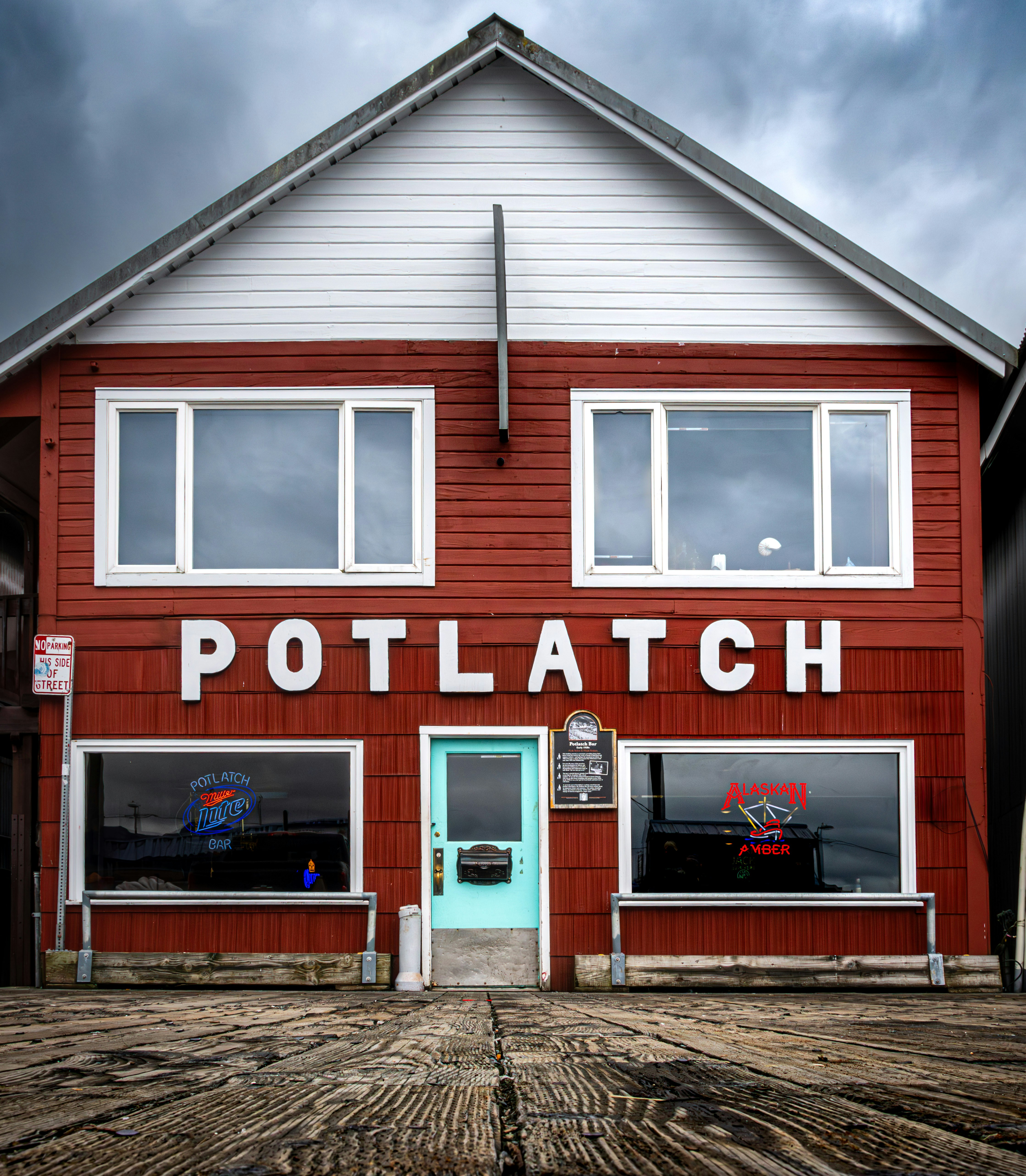 Potlatch Facade under a Moody Sky: Crimson Wood and a Teal Door