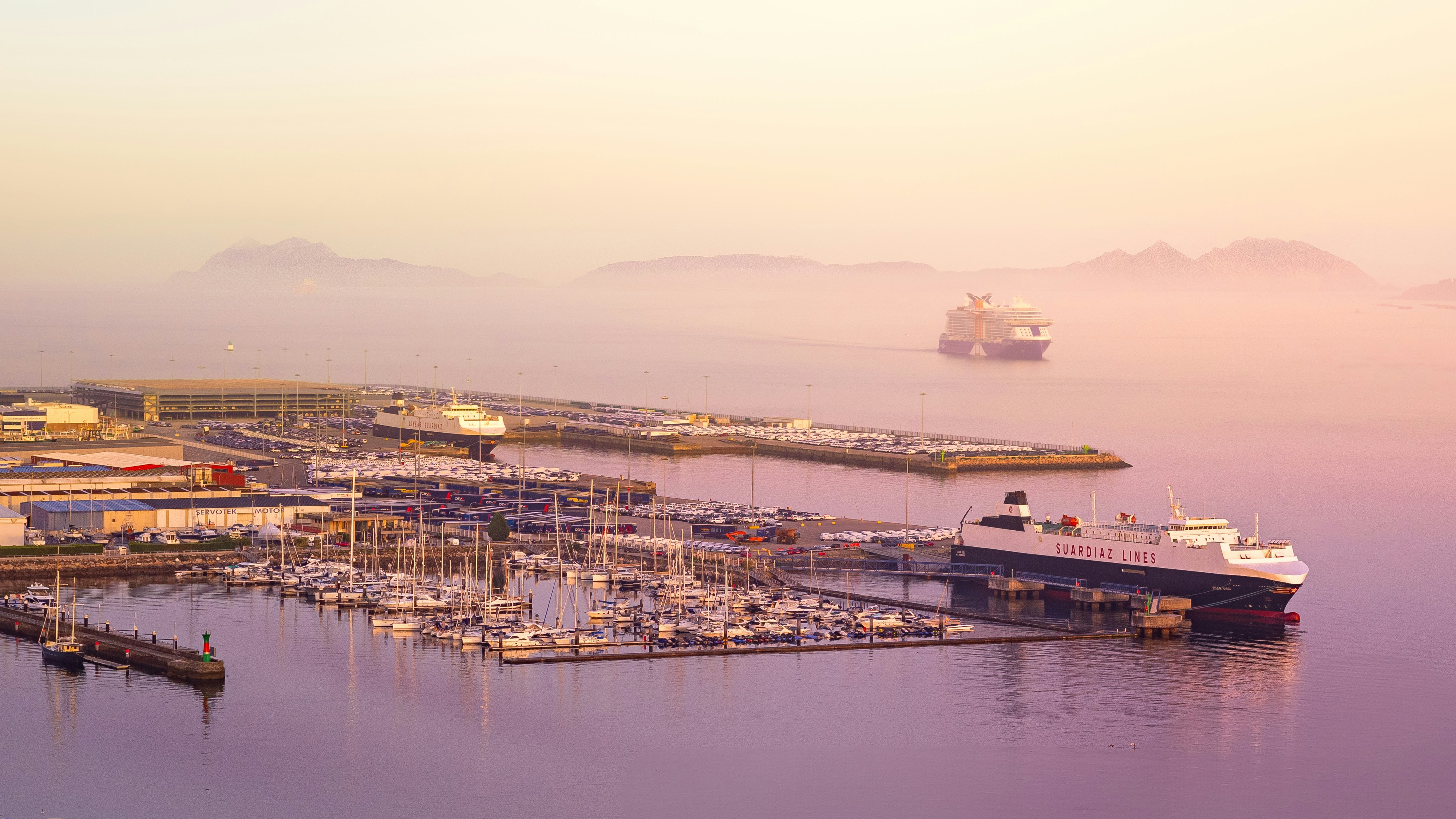 The harbor wakes up at dawn. Vigo, Galicia, Spain. | A large boat docked in a large body of water