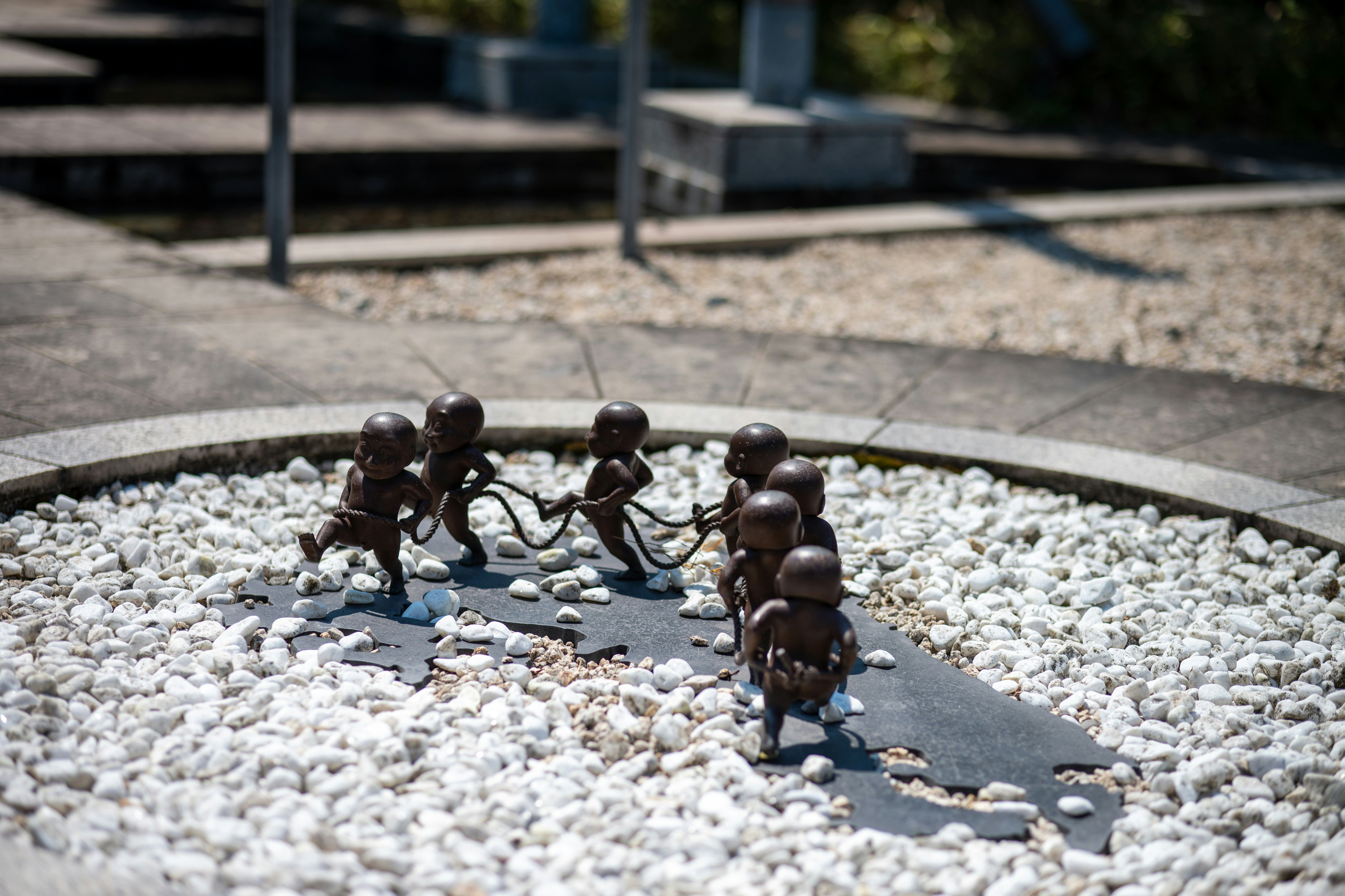A Quiet Parade: Tiny Figures in a Pebble Plaza